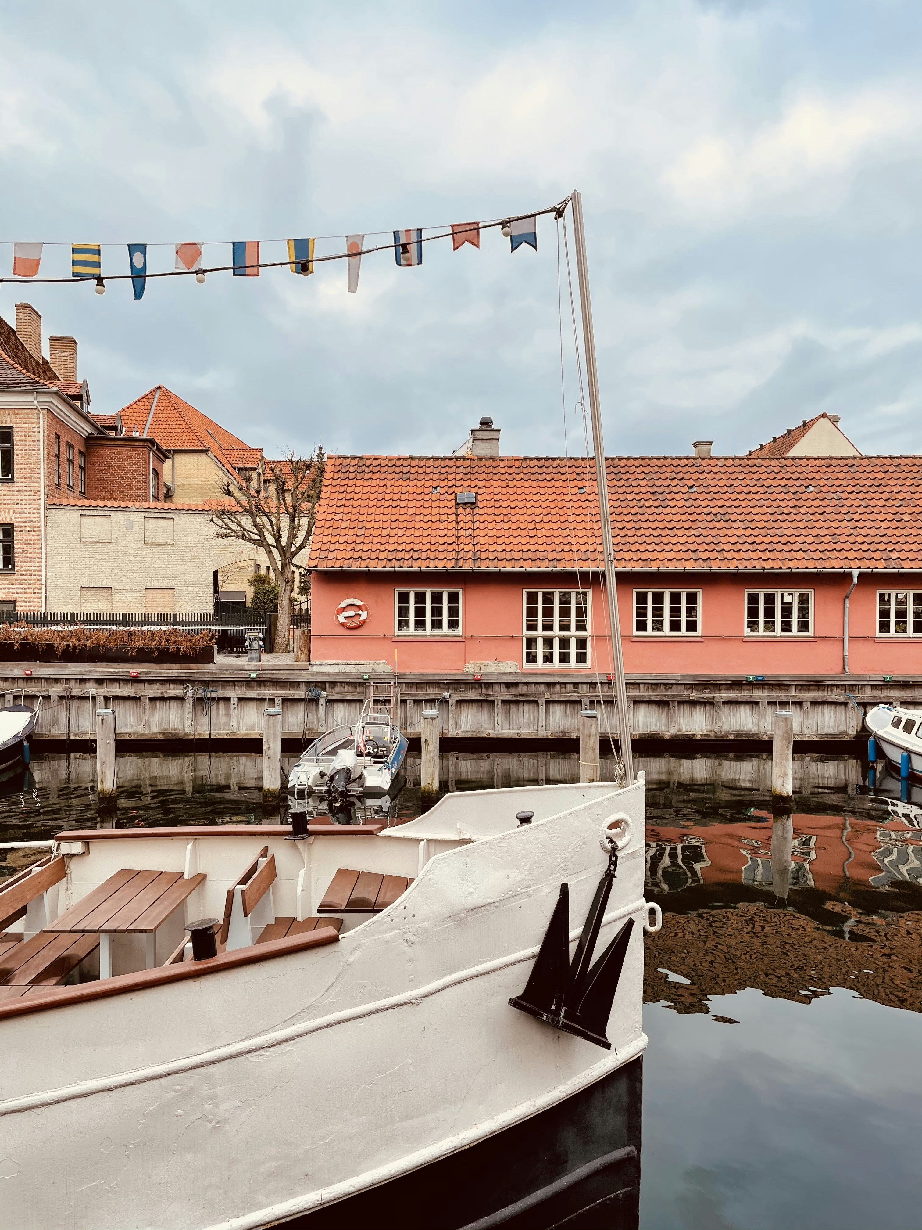 Harbor Light: White Boat Framed by a Coral Canalfront