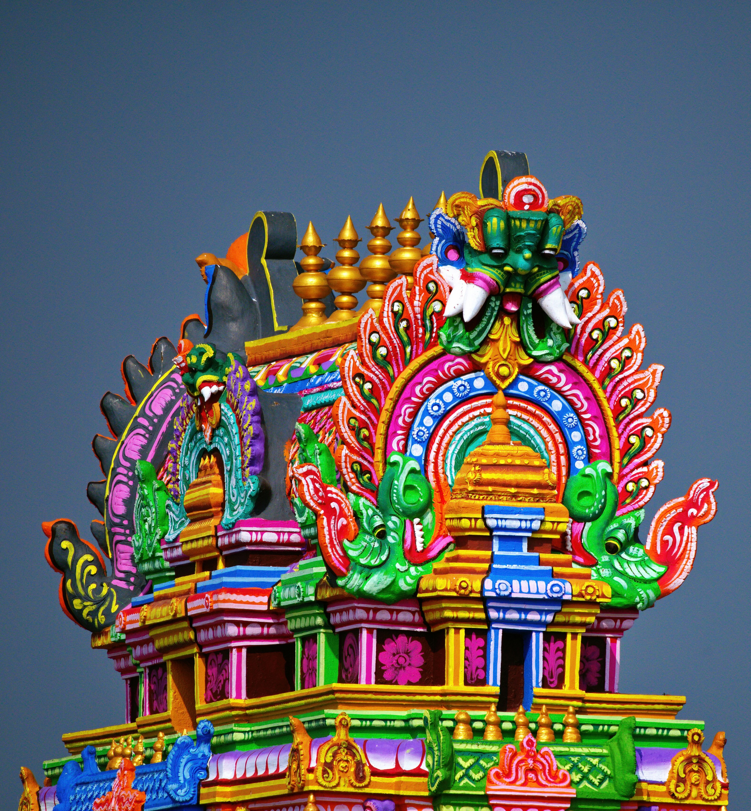 Intricately designed temple tower adorned with colorful sculptures and motifs, showcasing rich cultural heritage.