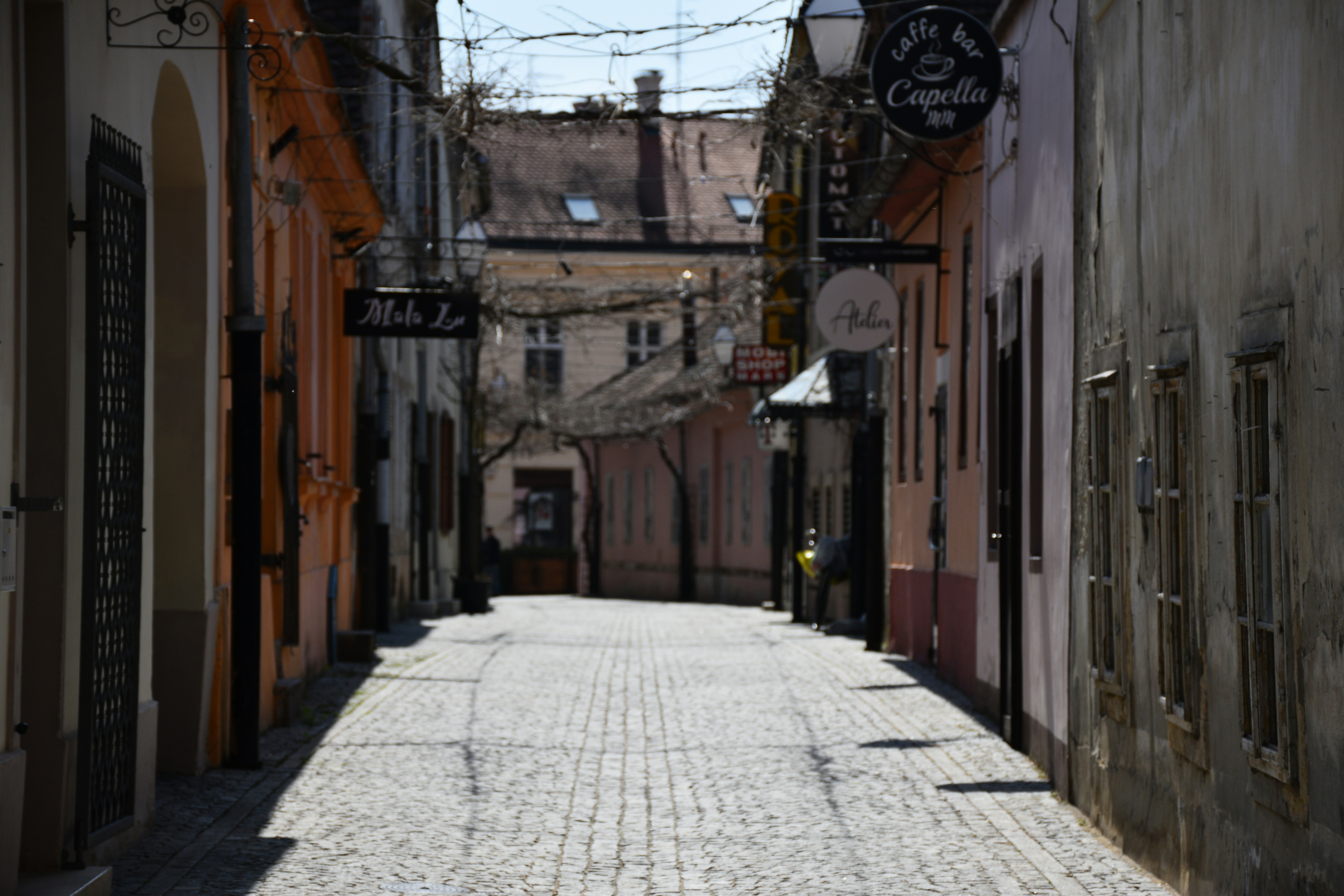 Cobbled Corridor: Sunlit Alley Toward a Distant Arch
