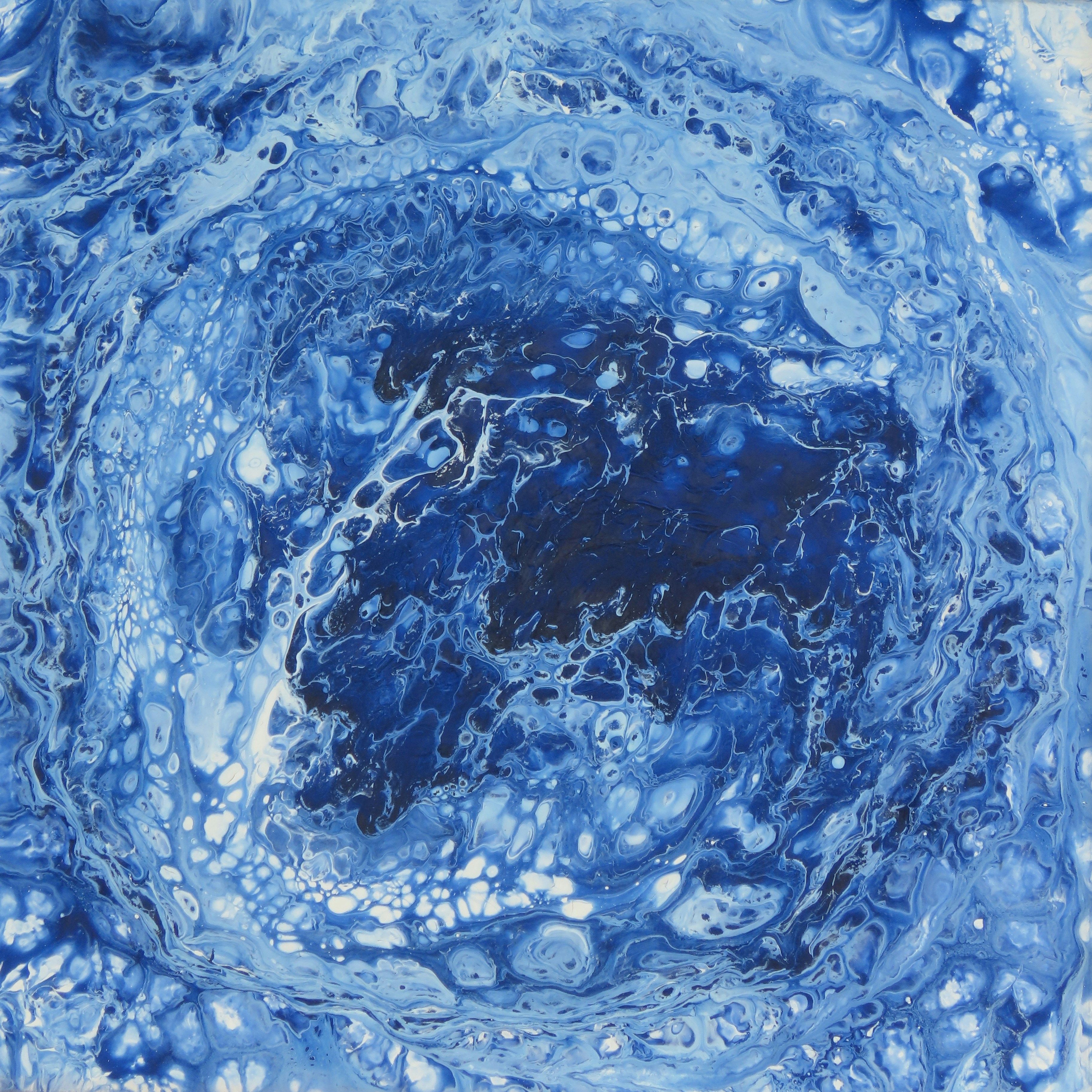 Abstract fluid art featuring swirling shades of blue and white, creating a dynamic, ocean-like texture. The interplay of colors evokes a sense of movement and depth.