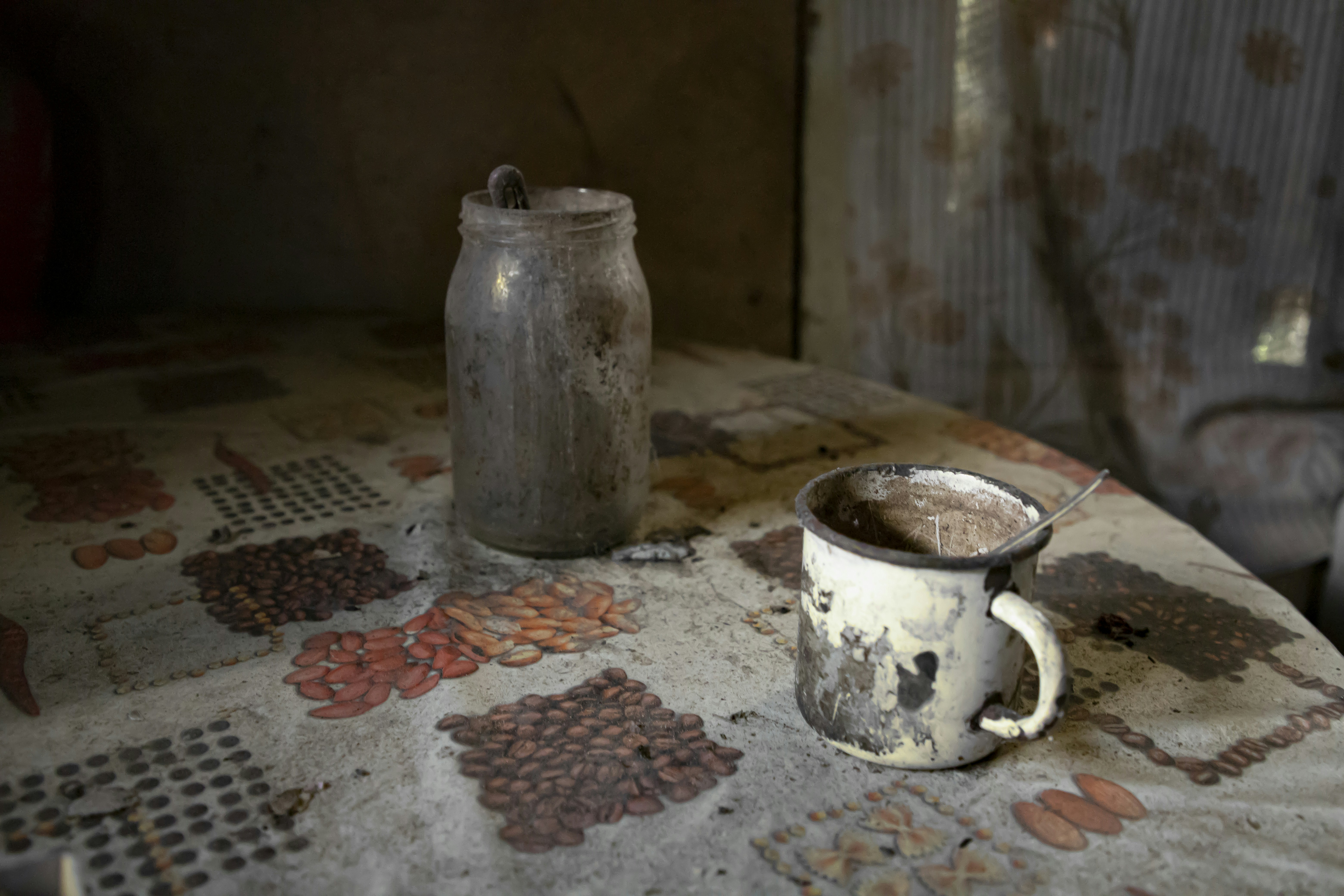 Dust and Rust: Weathered Mug and Mason Jar on a Patterned Tablecloth