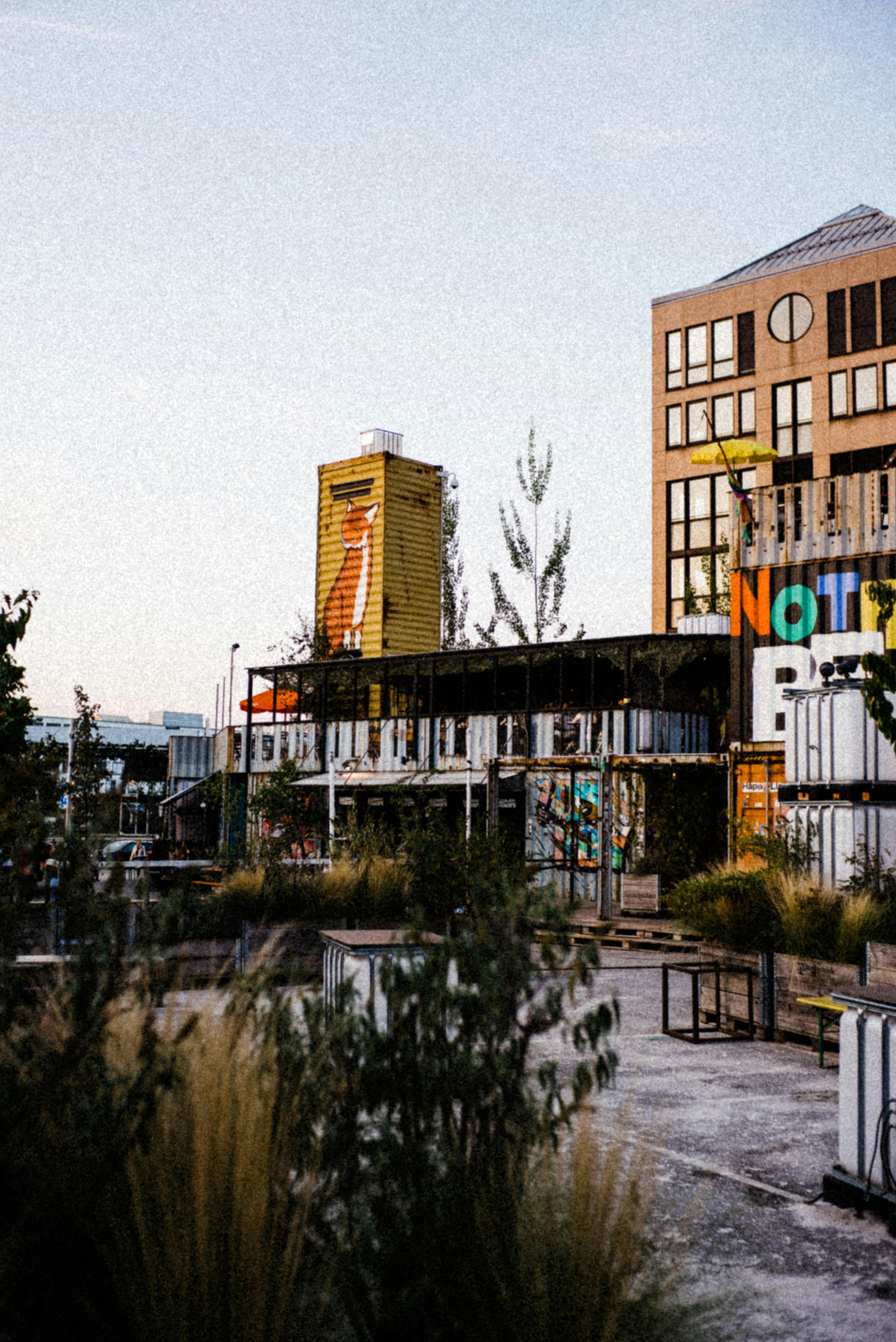 Foto Edificio de hormigón marrón cerca de los árboles durante el día – Imagen Werksviertel-mitte ...