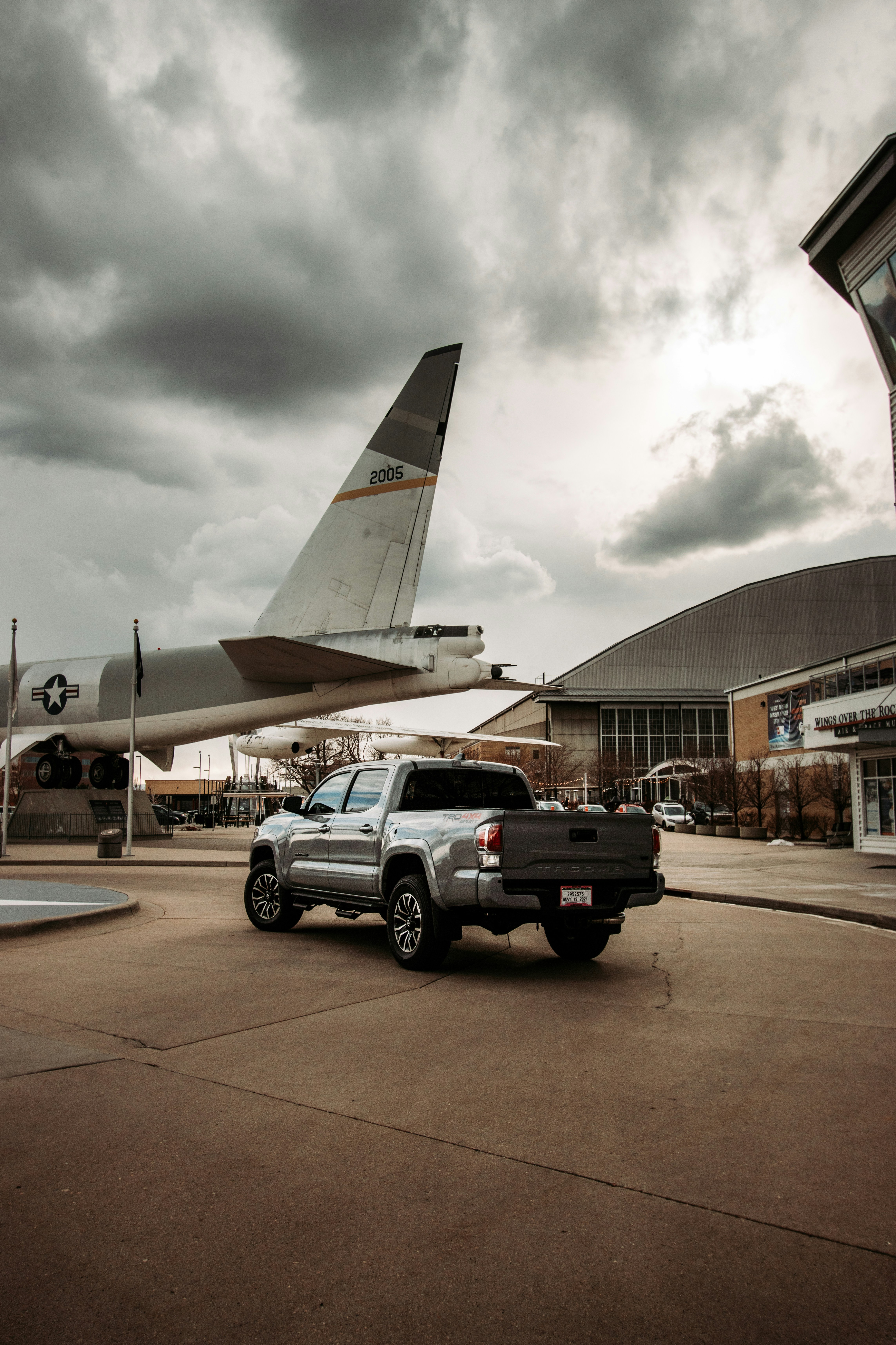 Tailwind on Display: A silver pickup beneath a museum jet
