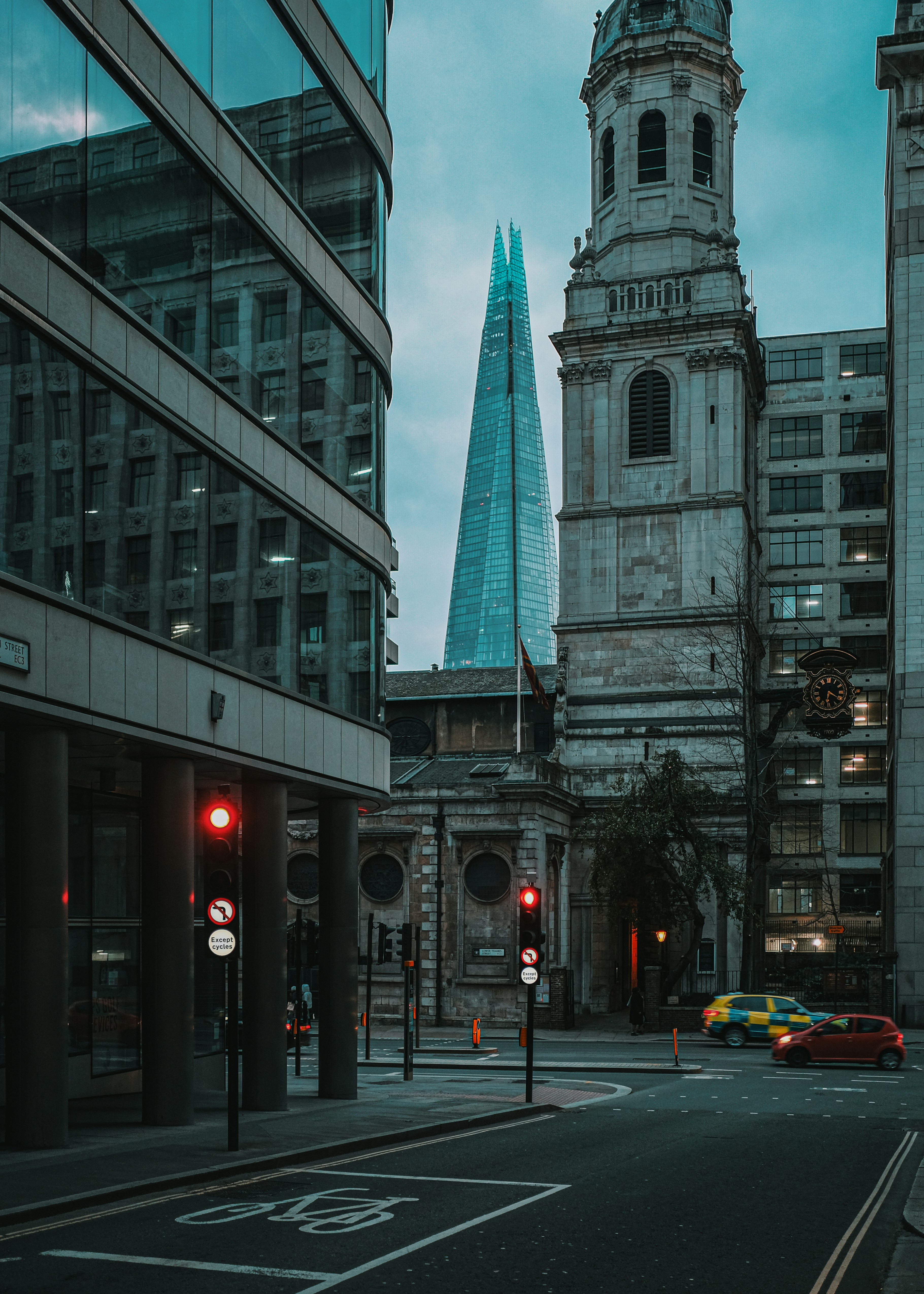 Historic church juxtaposed against modern skyscraper in a bustling city street, highlighting architectural diversity.