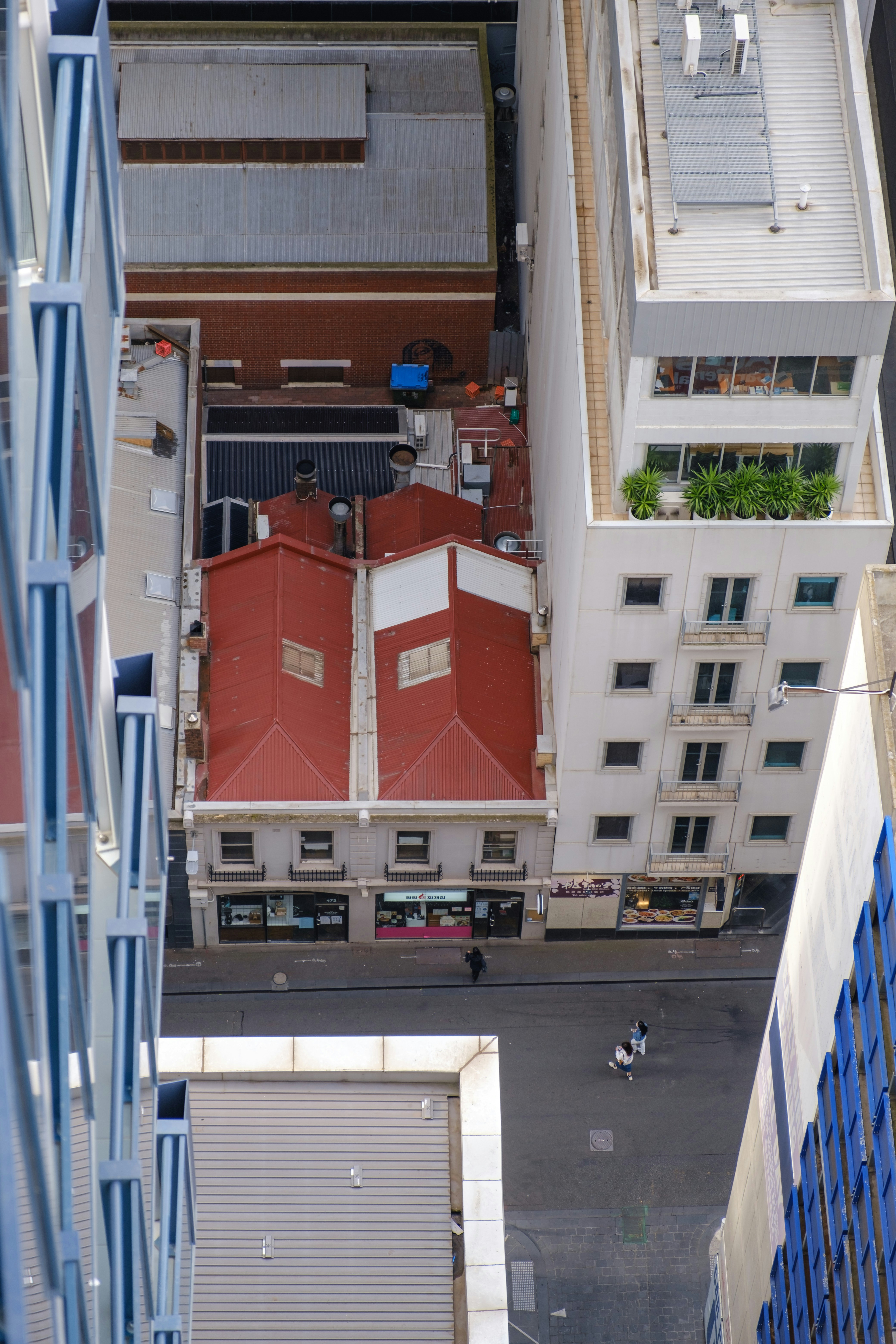 Aerial view showcasing a mix of modern and traditional architecture, highlighting red-roofed buildings amidst urban surroundings.