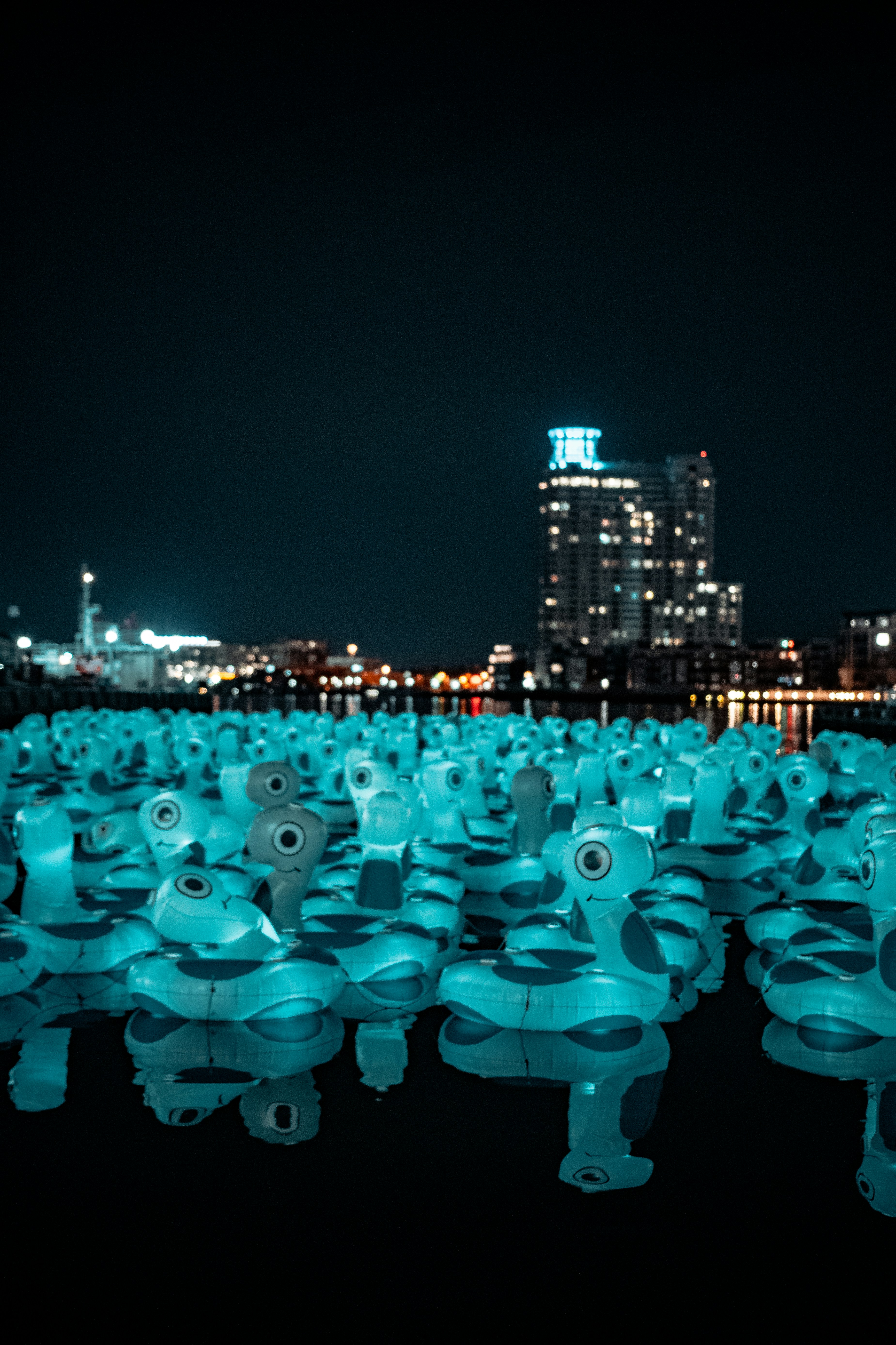 Midnight Parade of Teal Rubber Duck Inflatables by the City Skyline