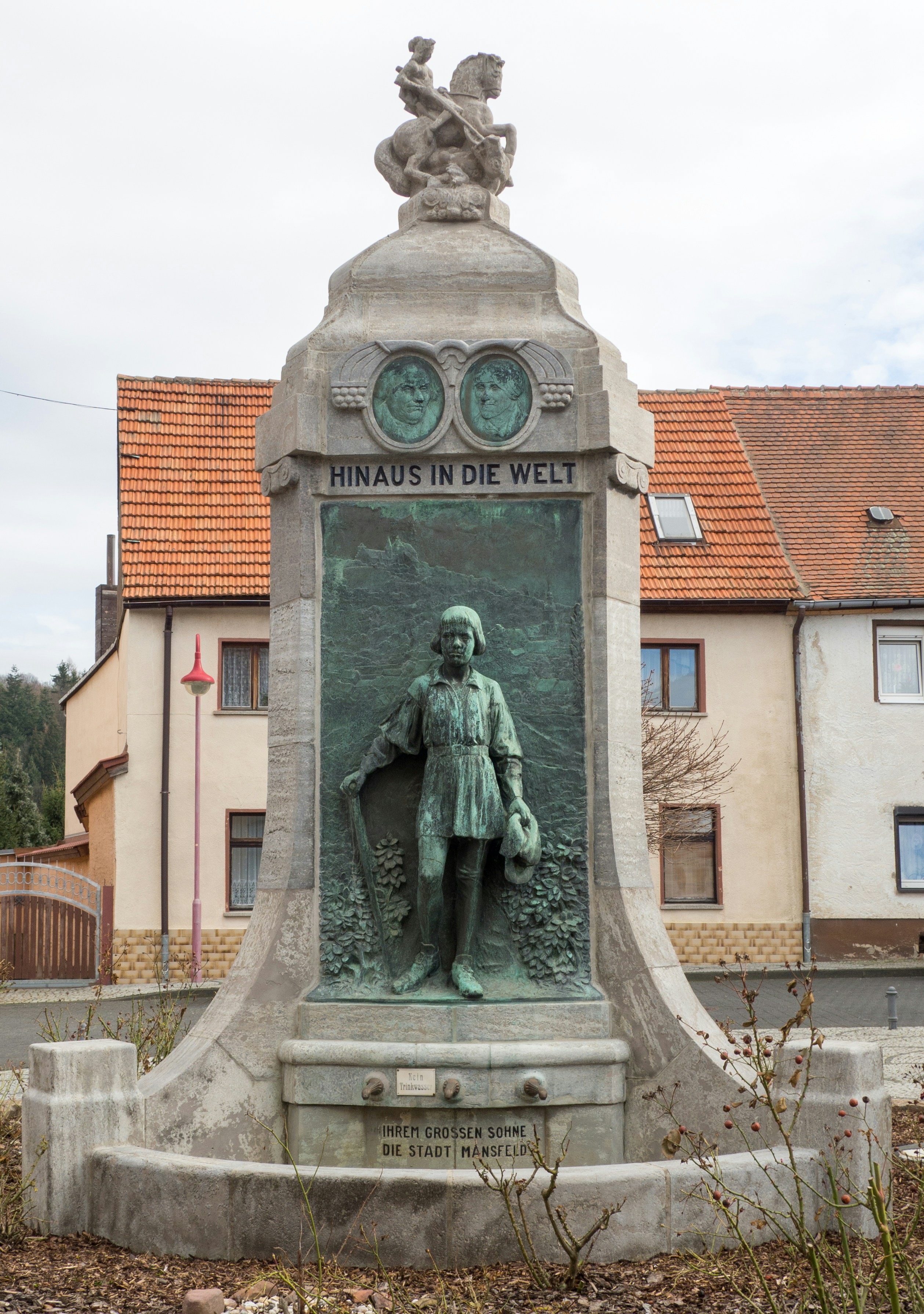 Monument to a Quiet Hero: Bronze Figure Framed by a Curved Stone Pedestal