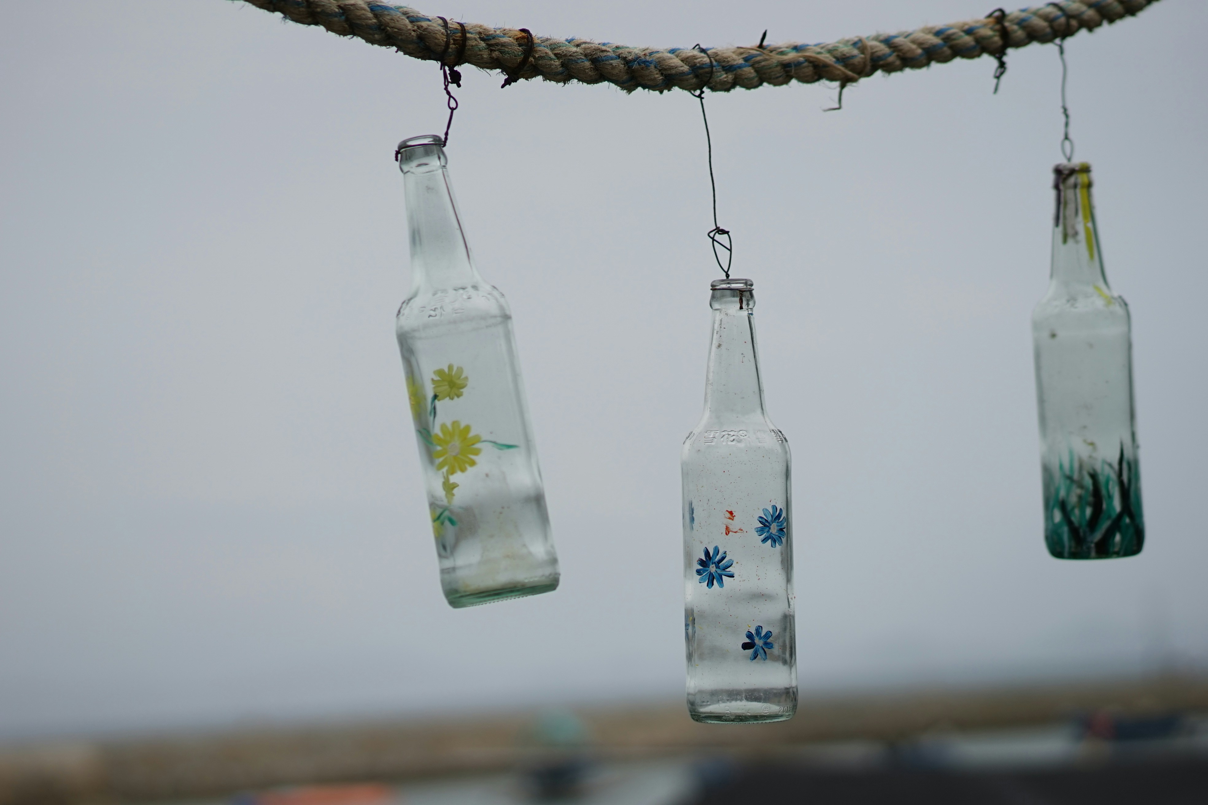 clear glass bottle hanging on brown rope
