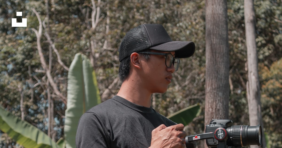 검은 색 Dslr 카메라를 들고 검은 색 크루 넥 티셔츠를 입은 남자 사진 Unsplash의 무료 케닌가우 이미지