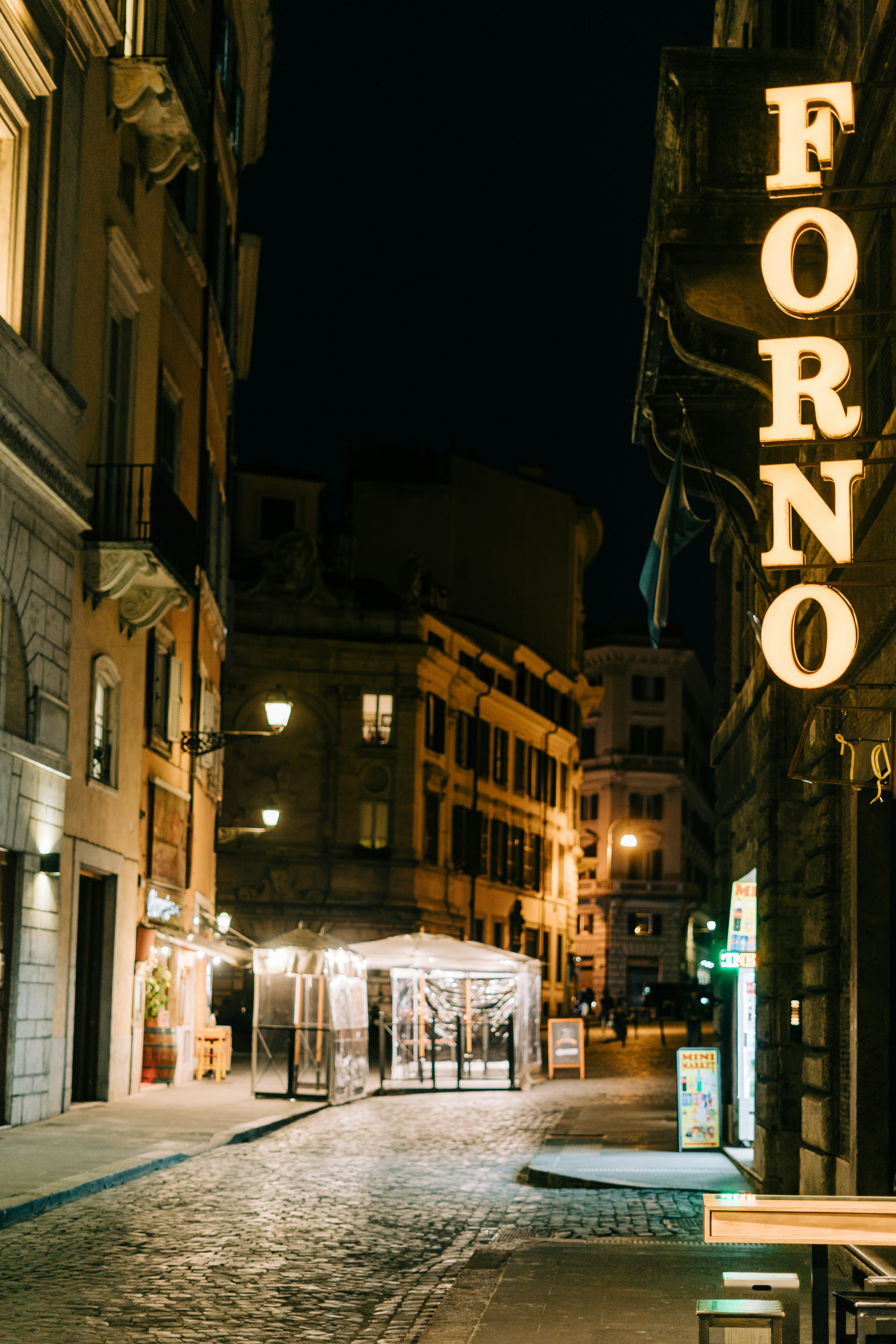 Neon Signage on a Cobblestone Night Street