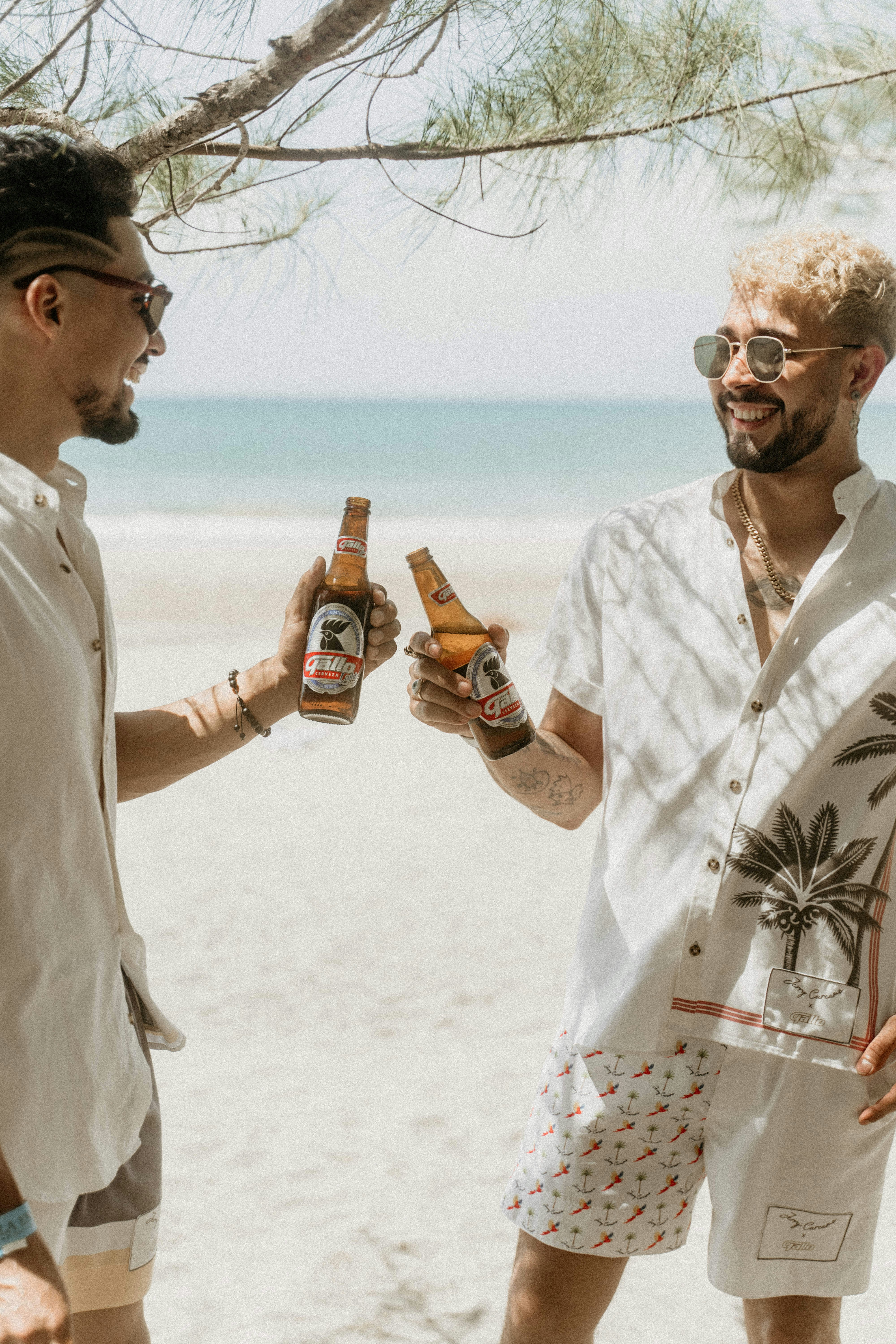 Sunlit cheers on the seaside: two friends toasting under the shade