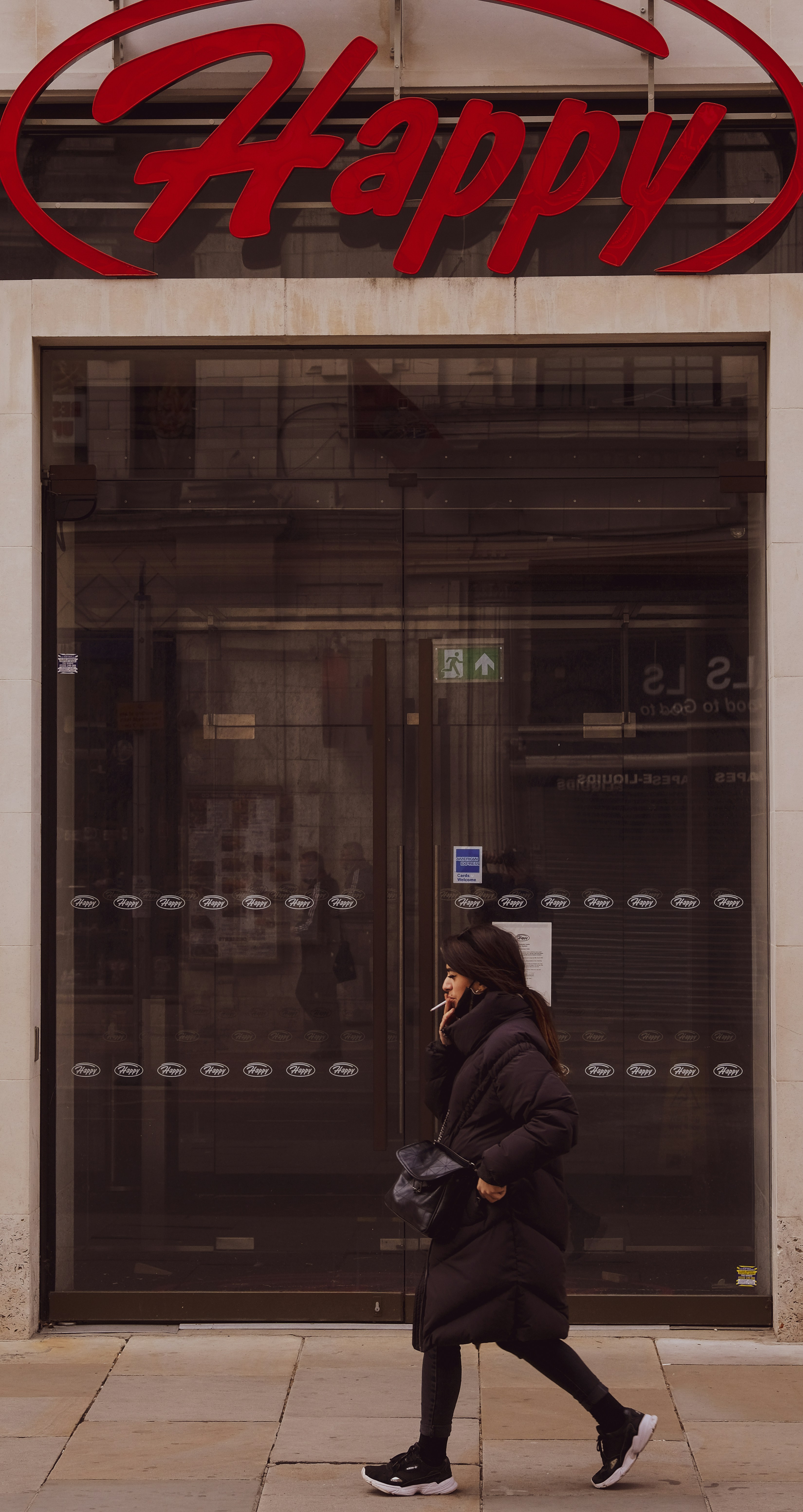 man in black jacket standing in front of glass window