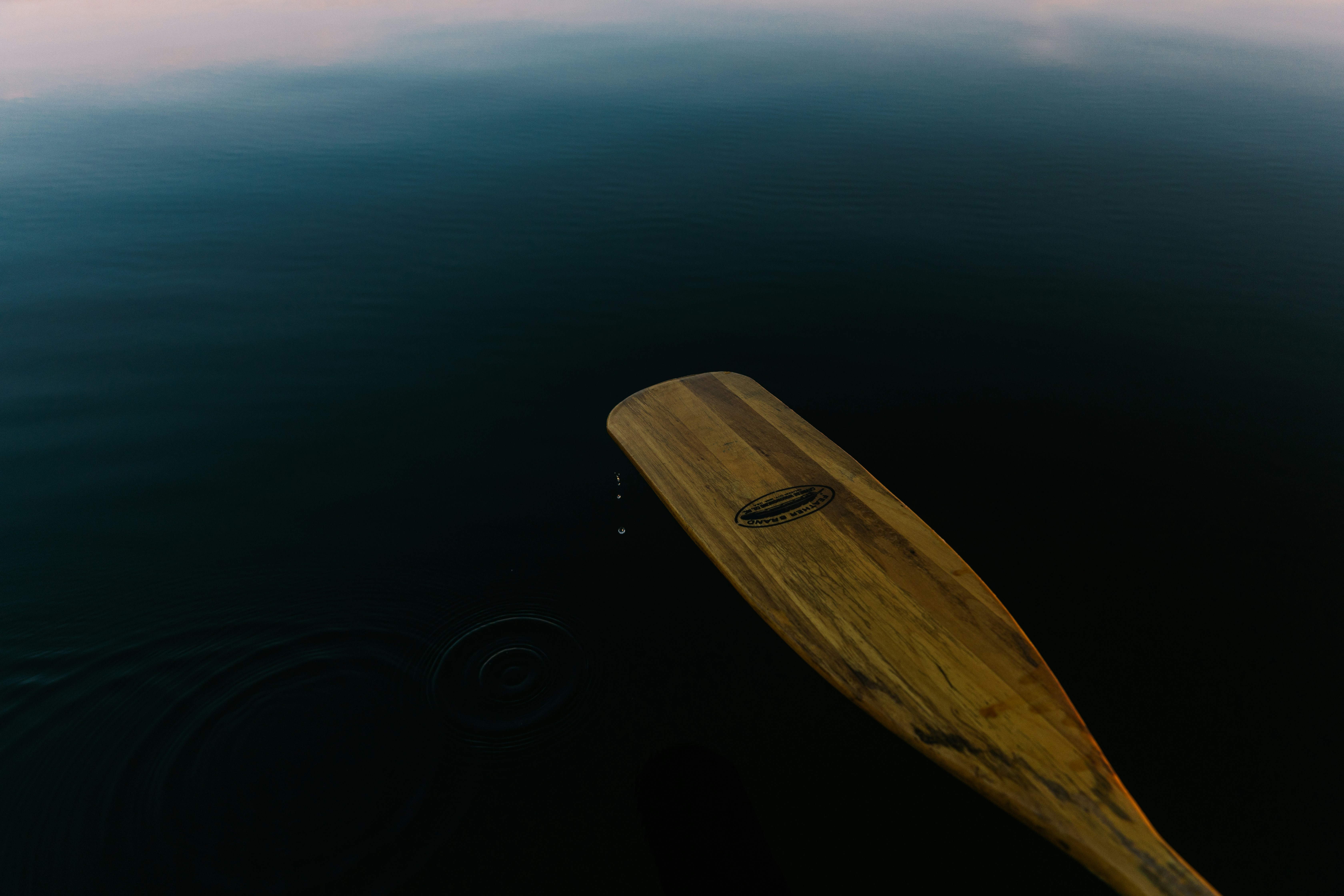 brown wooden paddle on body of water