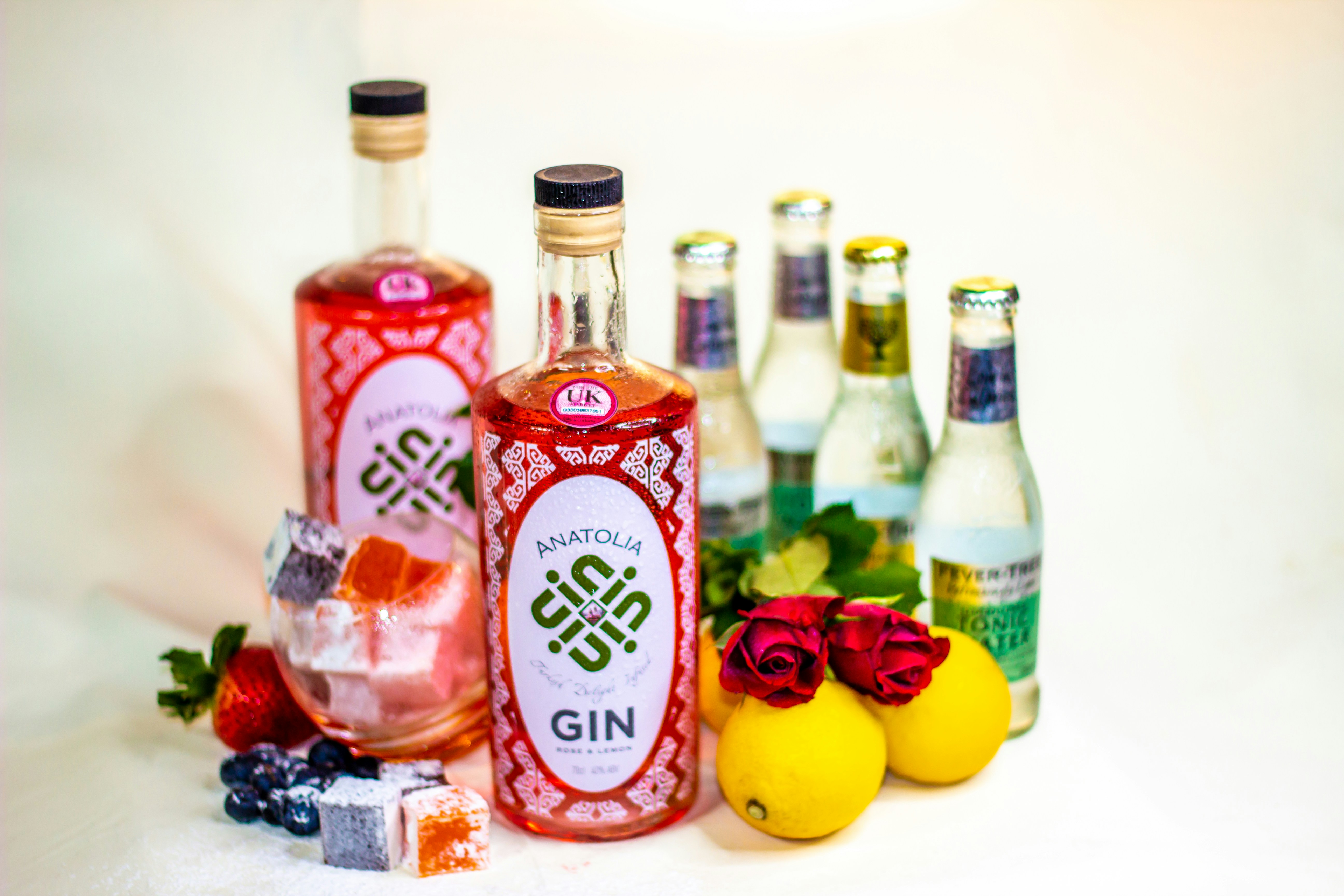Core Gin Moment: A trio of Anatolian gin bottles framed with citrus and rose accents