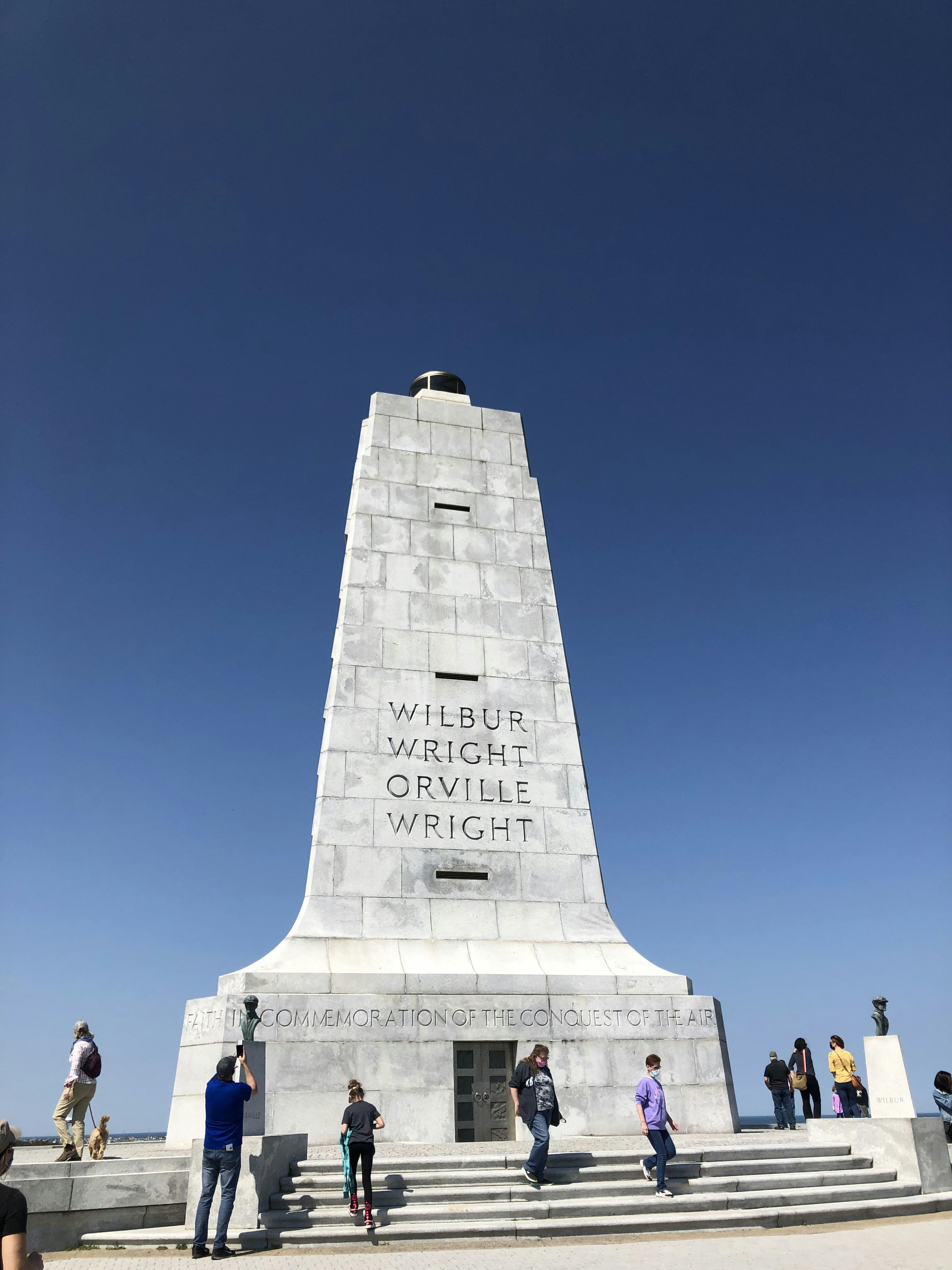 Wright Brothers National Memorial monument towering against a clear blue sky, honoring aviation pioneers Wilbur and Orville Wright.
