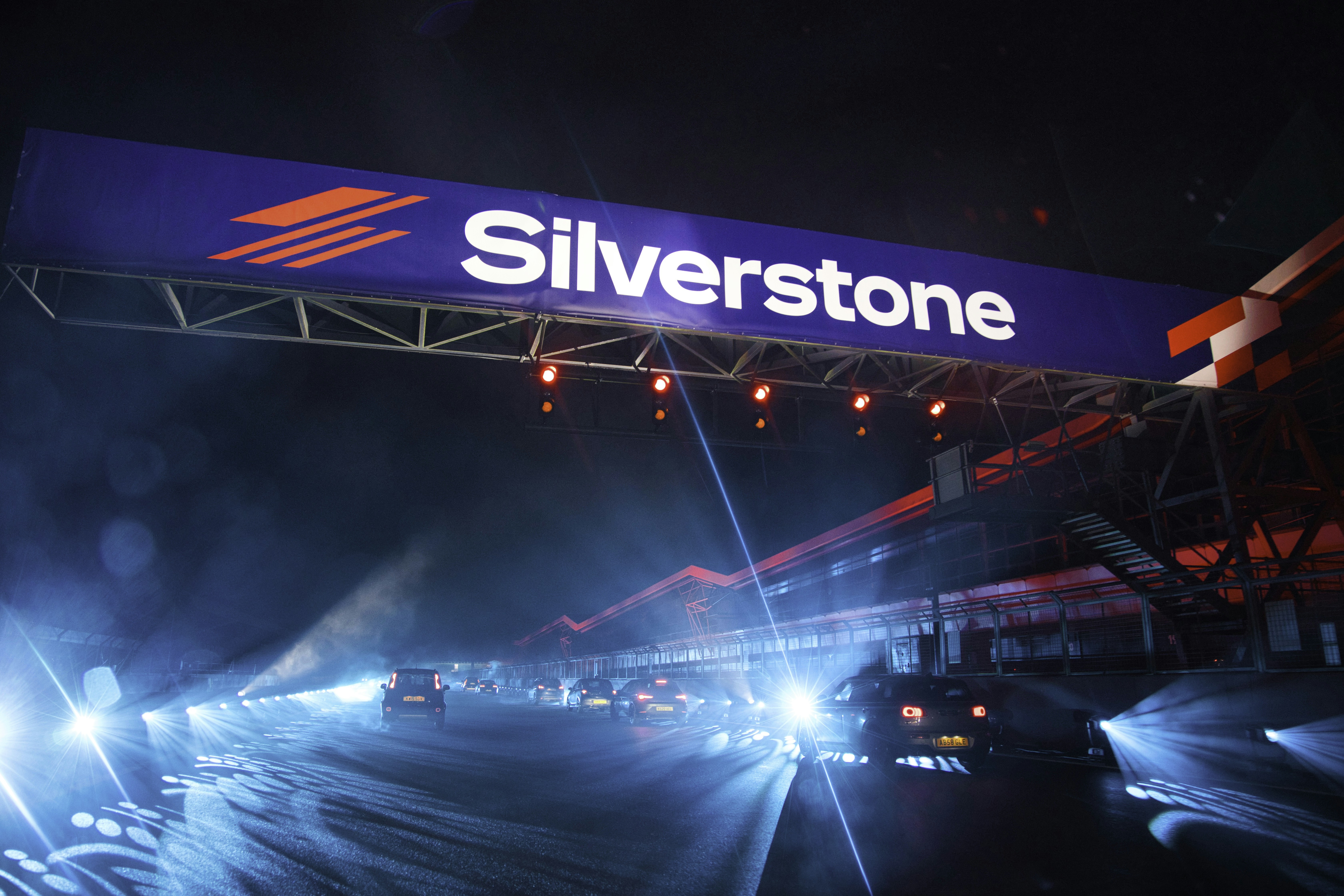 A silver stone sign above a highway at night photo – Free Silverstone ...