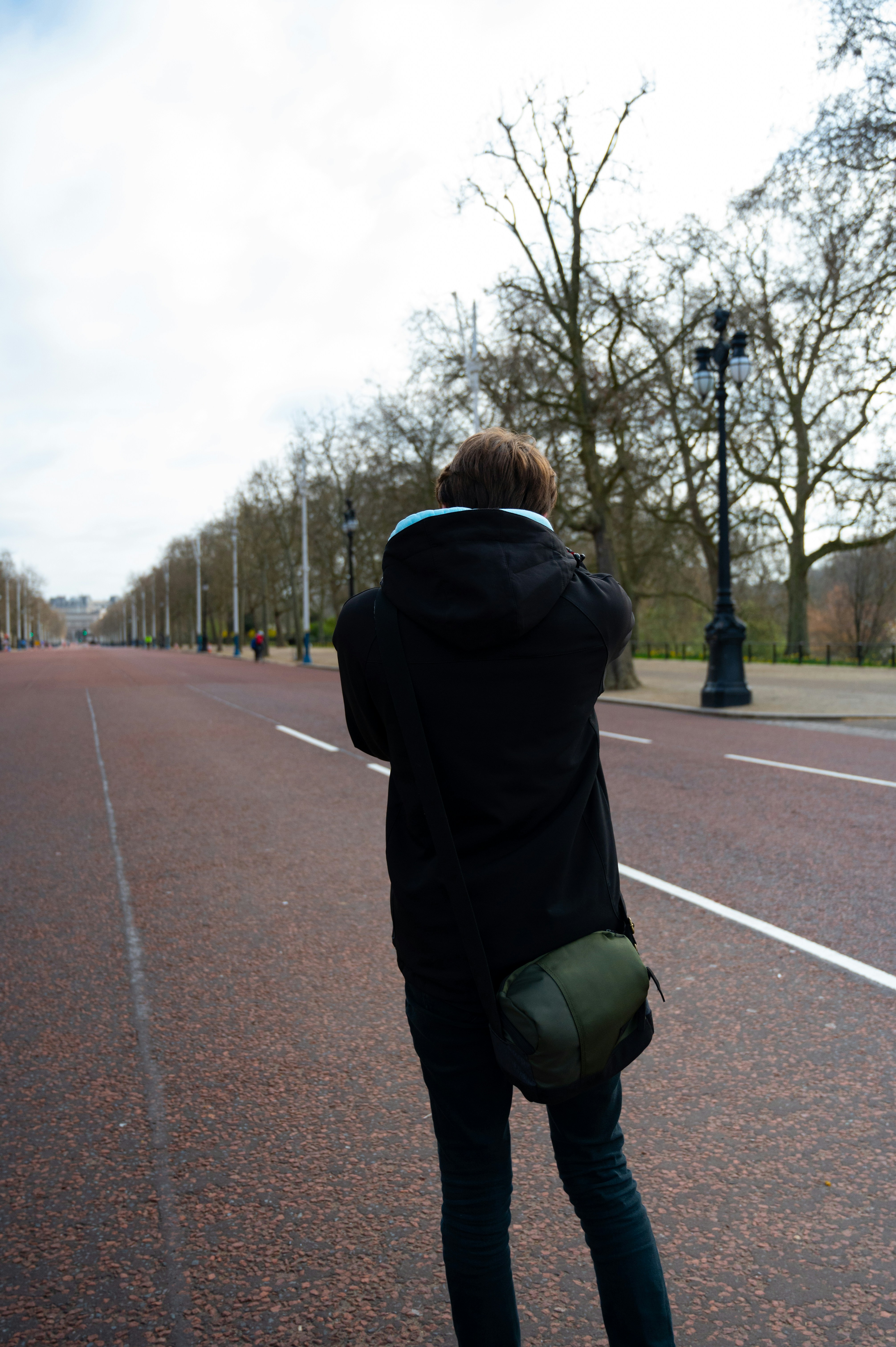 Back of the Lens: A lone photographer on a tree-lined boulevard