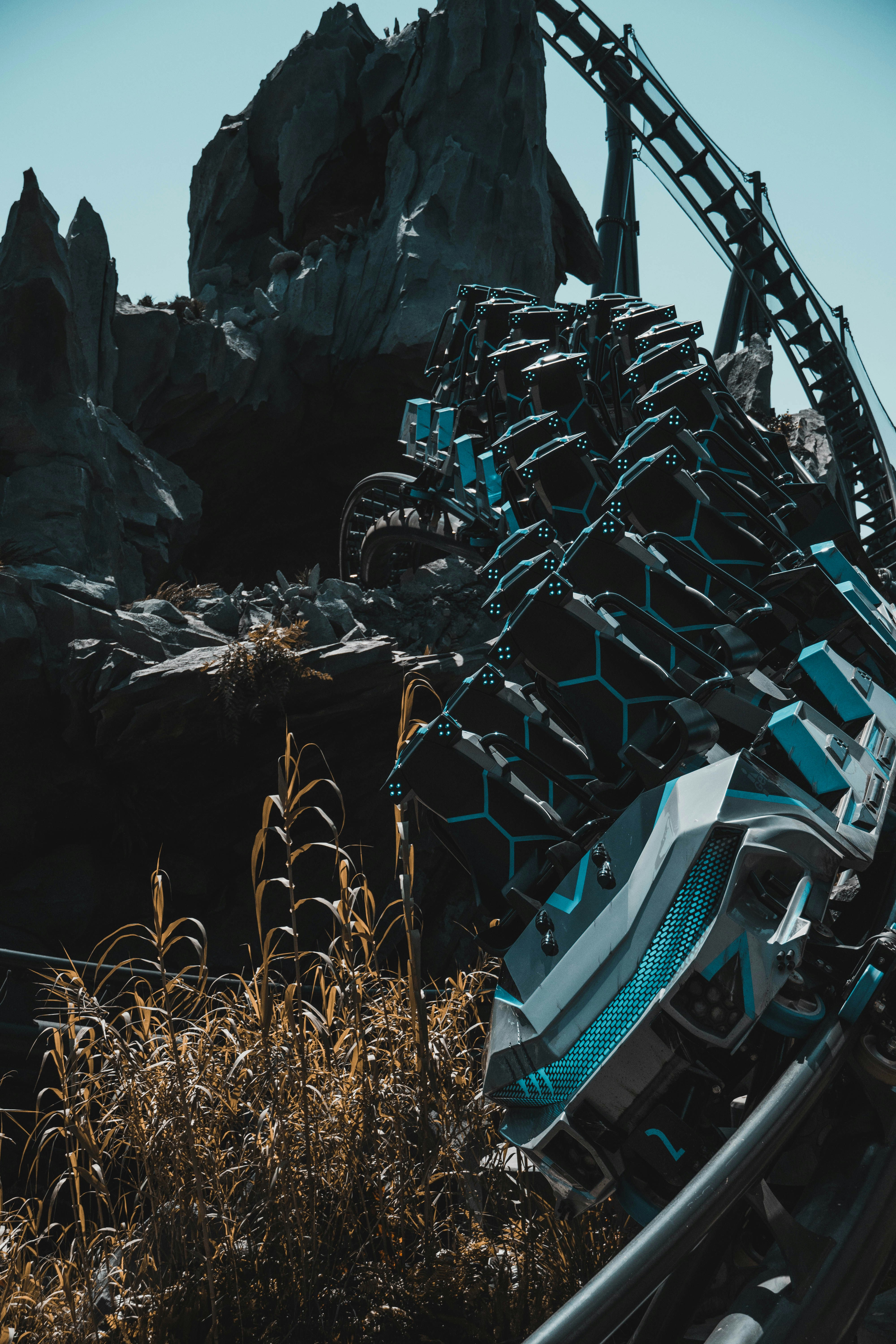 Blue Hex-Grid Behemoth Climbing a Jagged Cliff