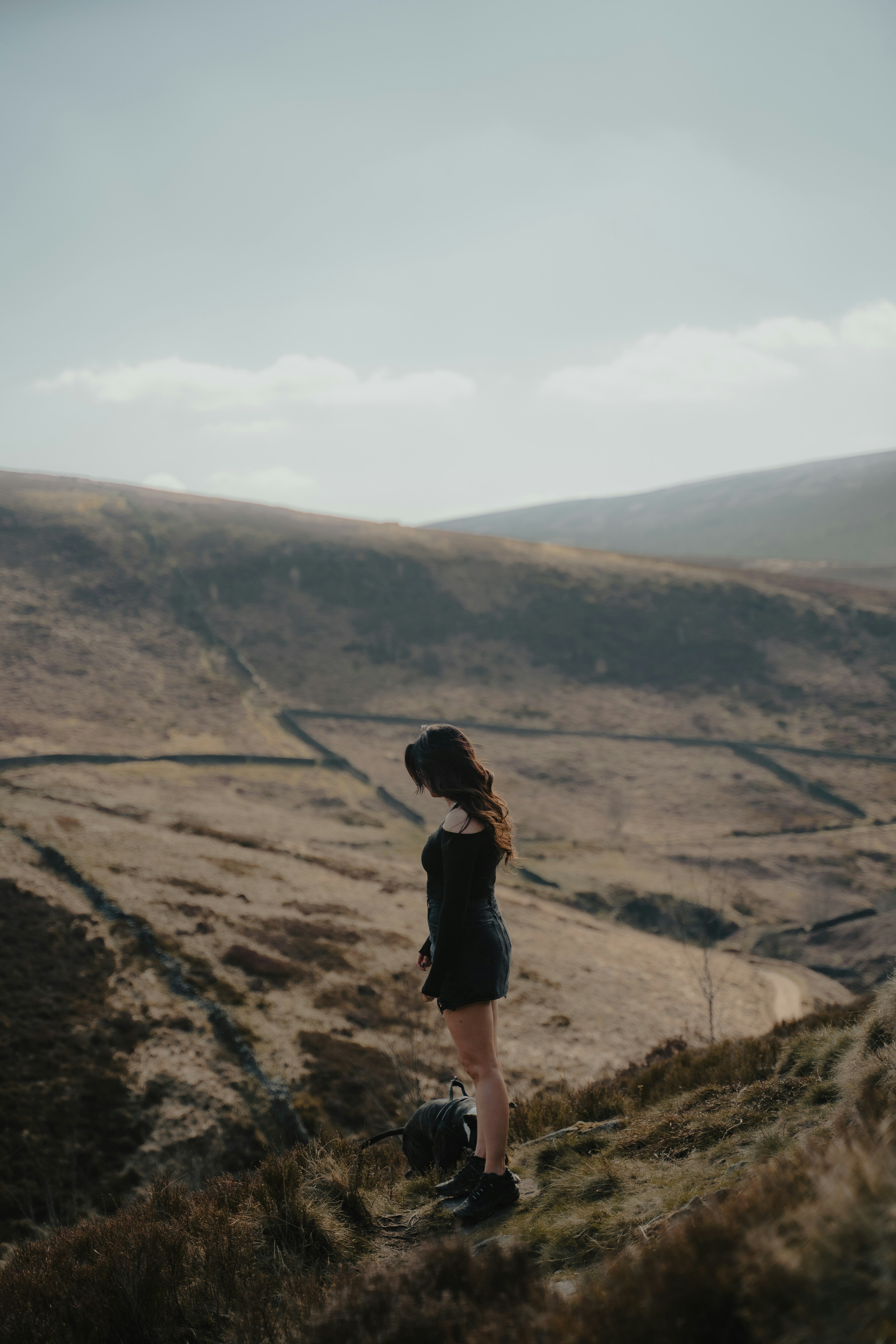 Silhouette at the Edge: A Lone Figure Above the Winding Moor