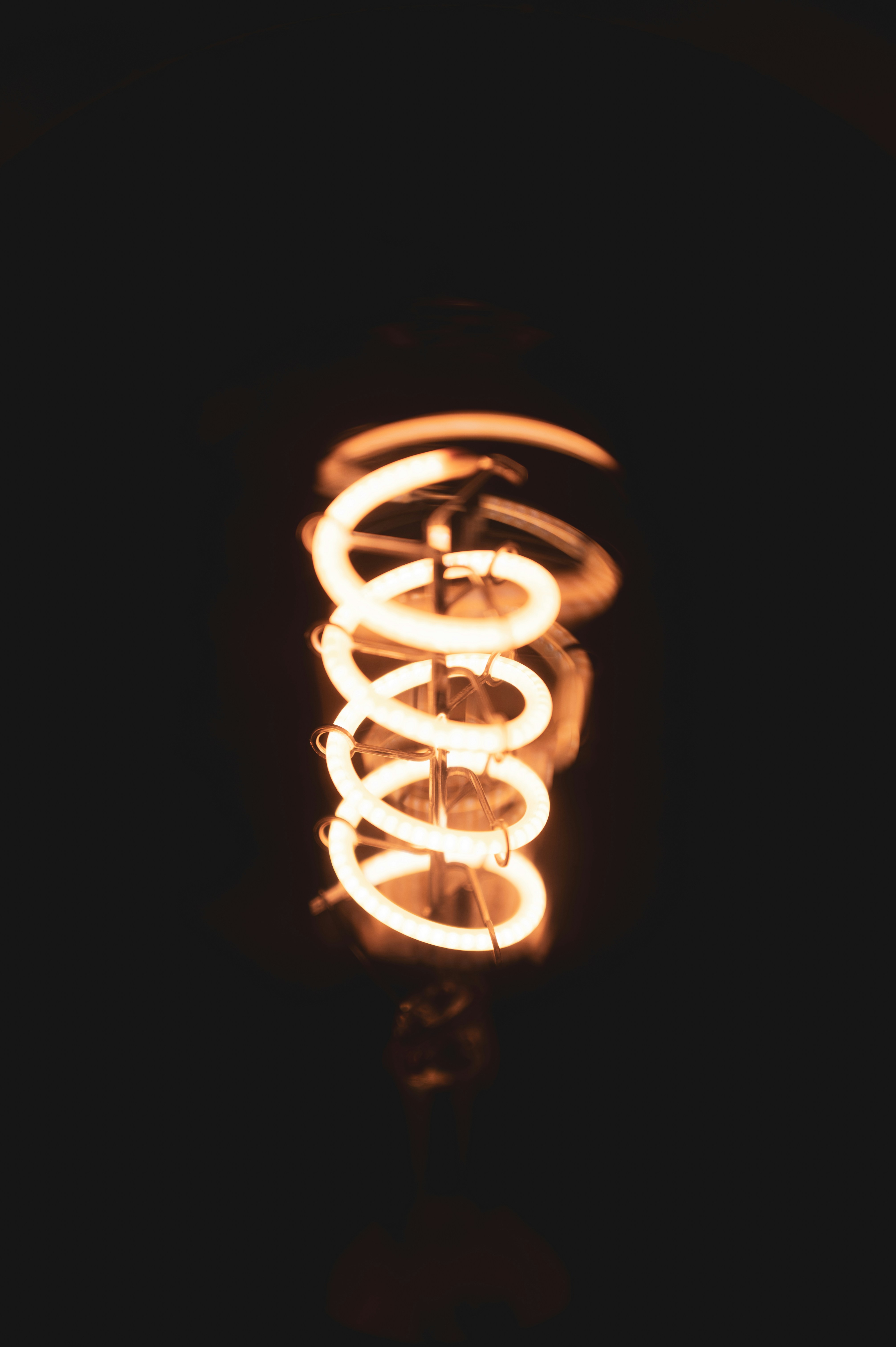 Helix of Warm Light: a solitary tungsten coil defies the dark.