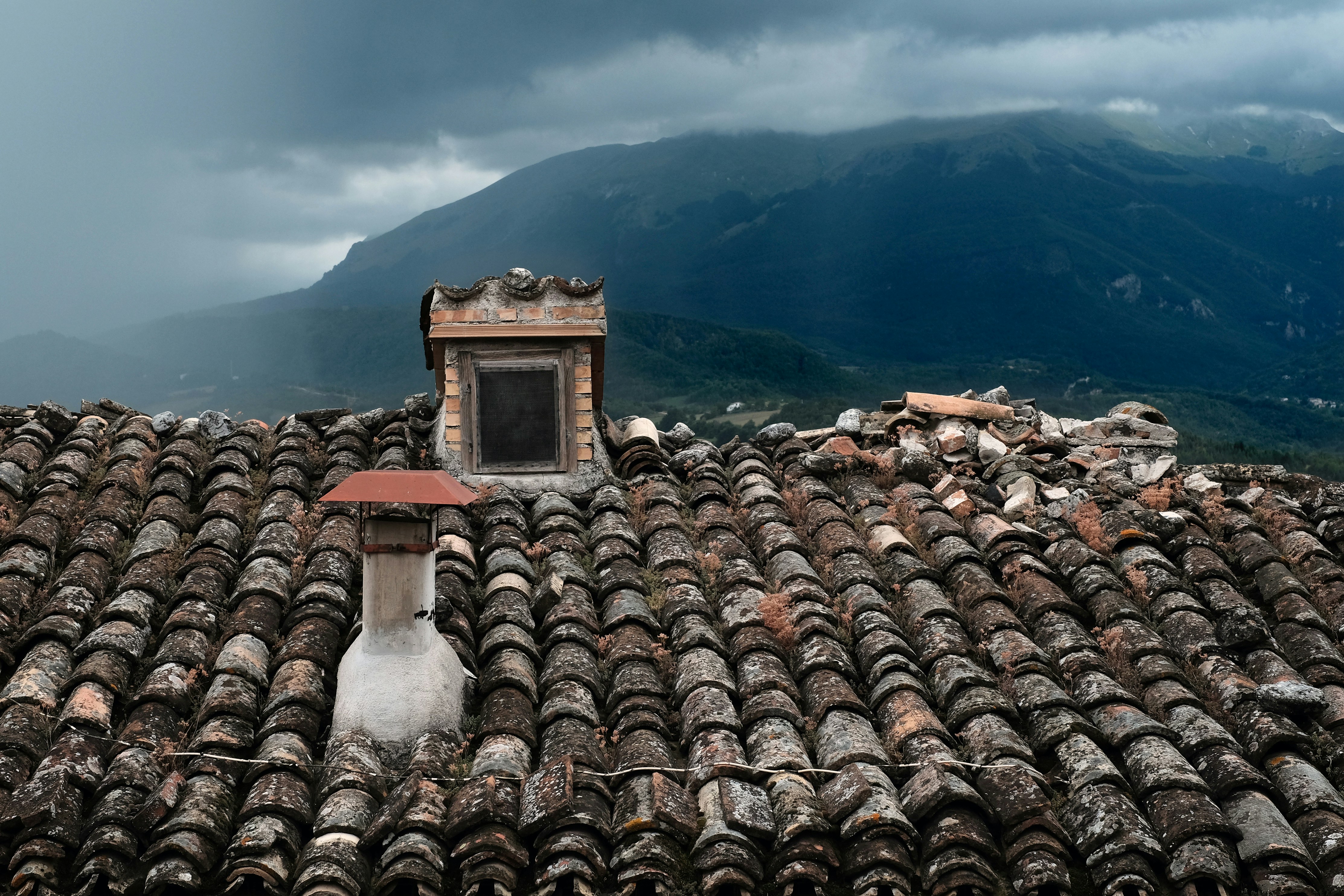 Roof tiles on Montefortino - Italy | brown roof tiles near body of water during daytime