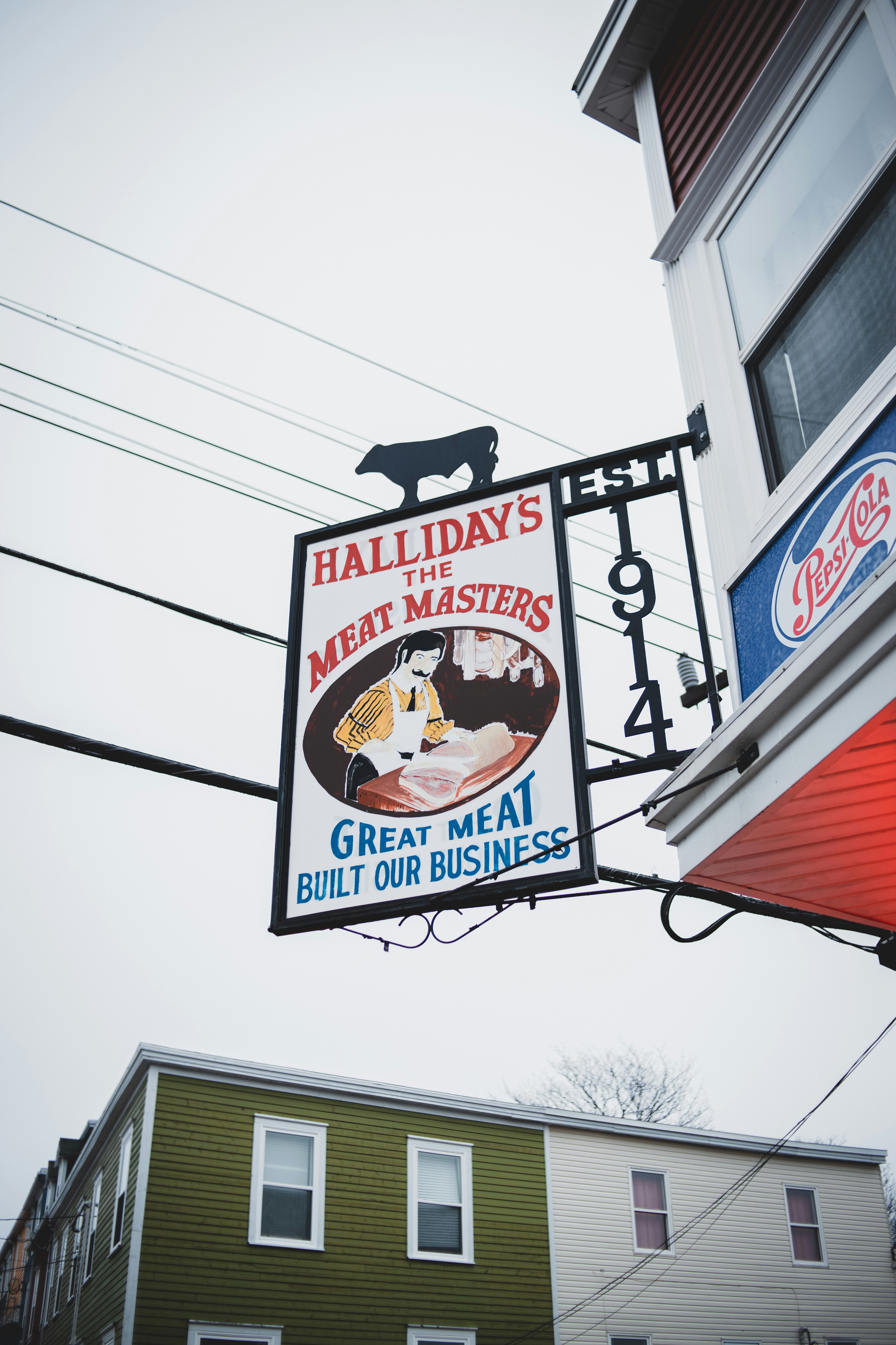 Signboard Serenade: Halliday's Meat Masters Over the Street