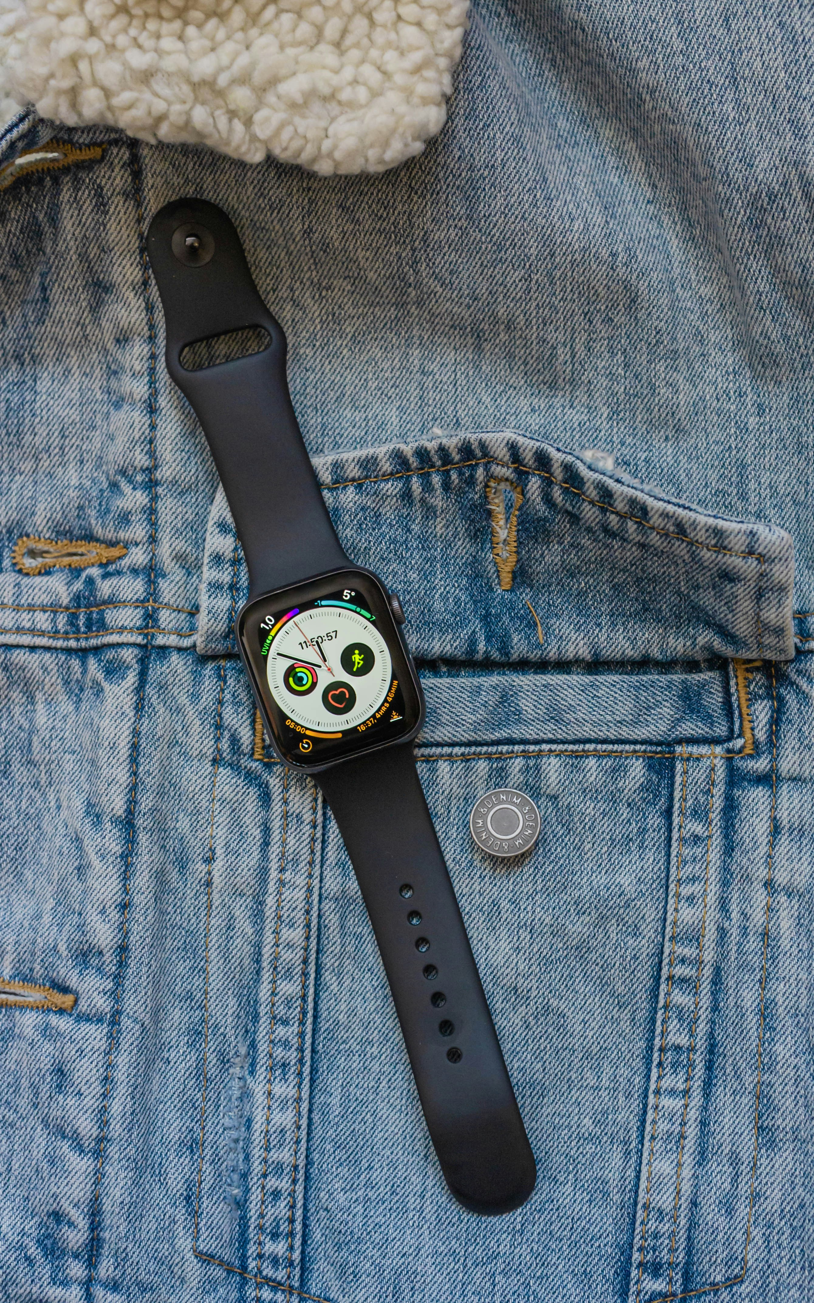 Smartwatch displaying a vibrant interface resting on a denim jacket, highlighting the contrast between modern technology and classic fabric.
