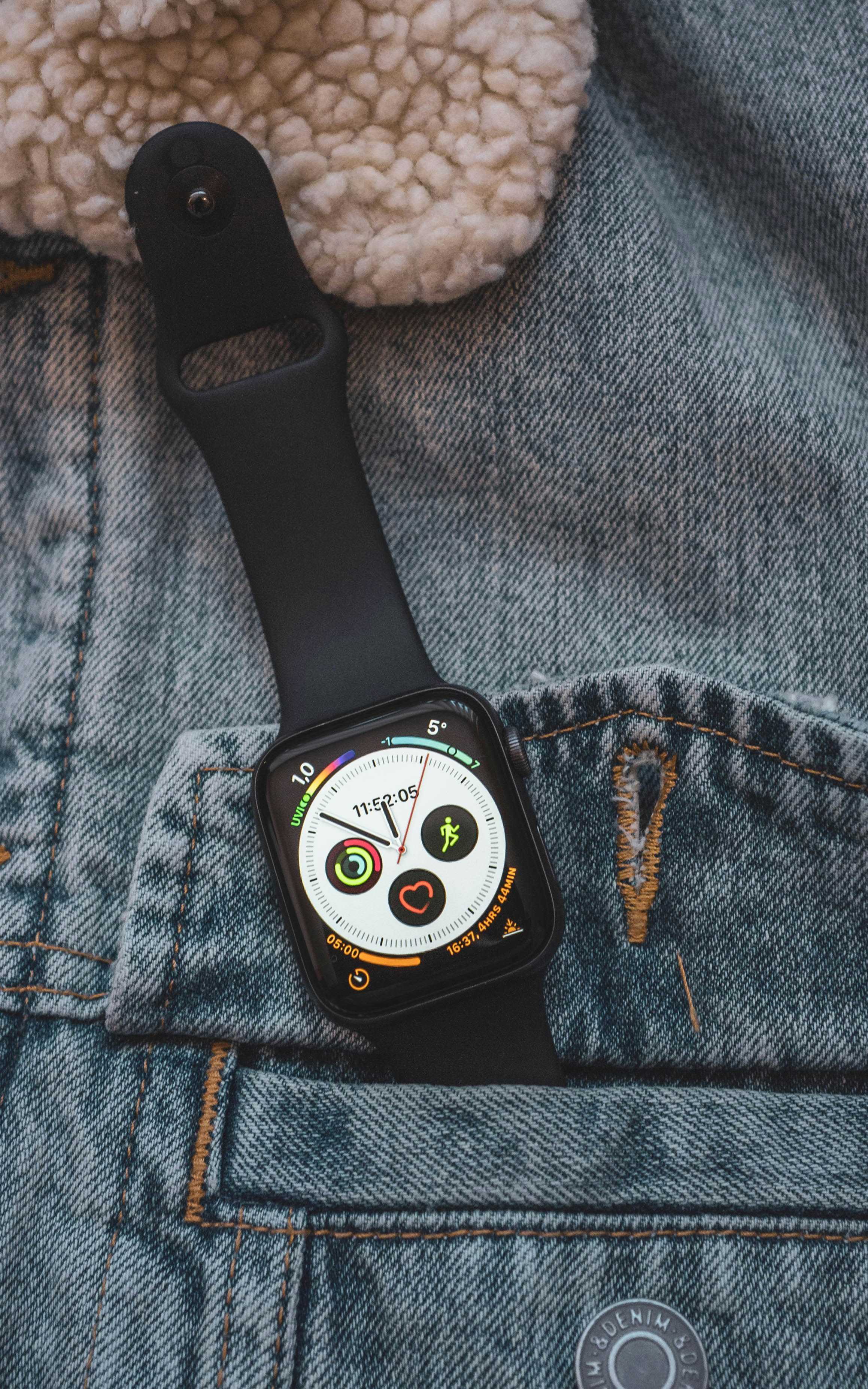 Apple Watch Series 4 with a black band on a denim jacket pocket