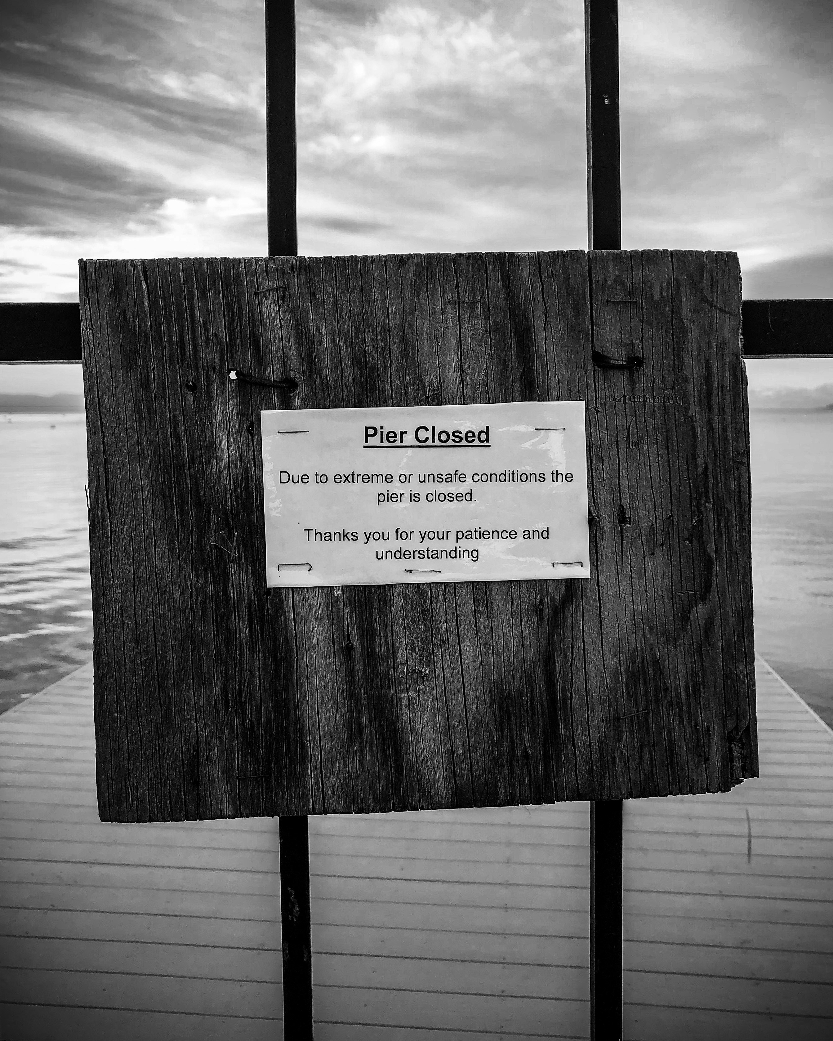 Weathered Pier Closed Sign: Quiet Geometry Between Rails