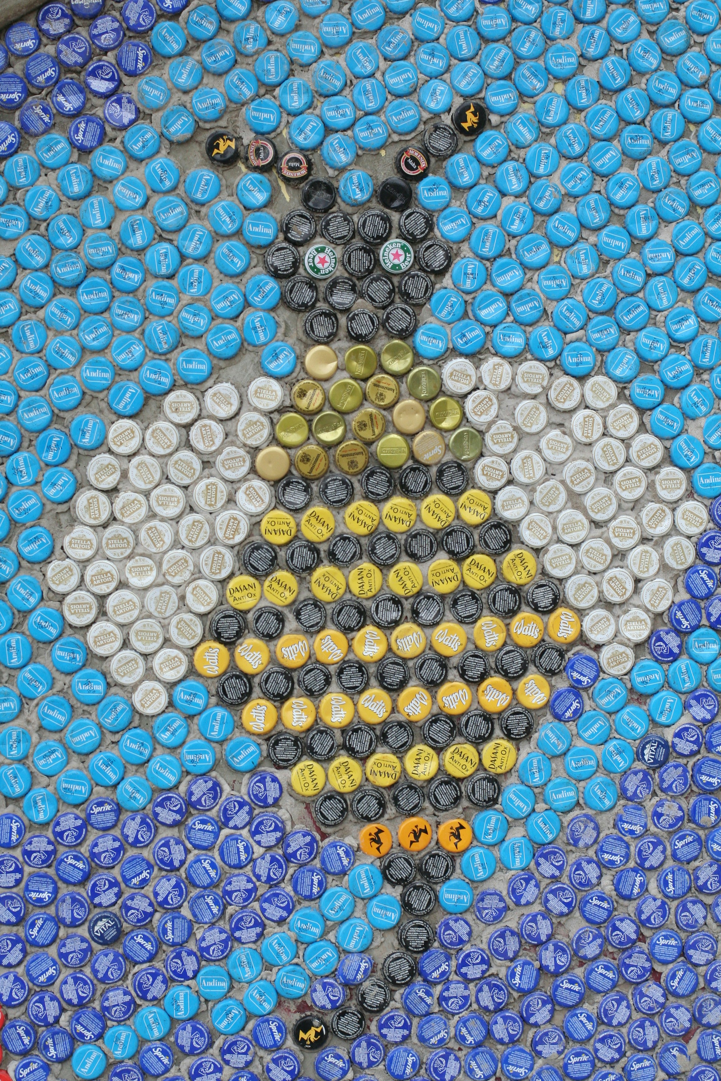 Capscape Penguin: a bottle-cap mosaic under a cerulean sky