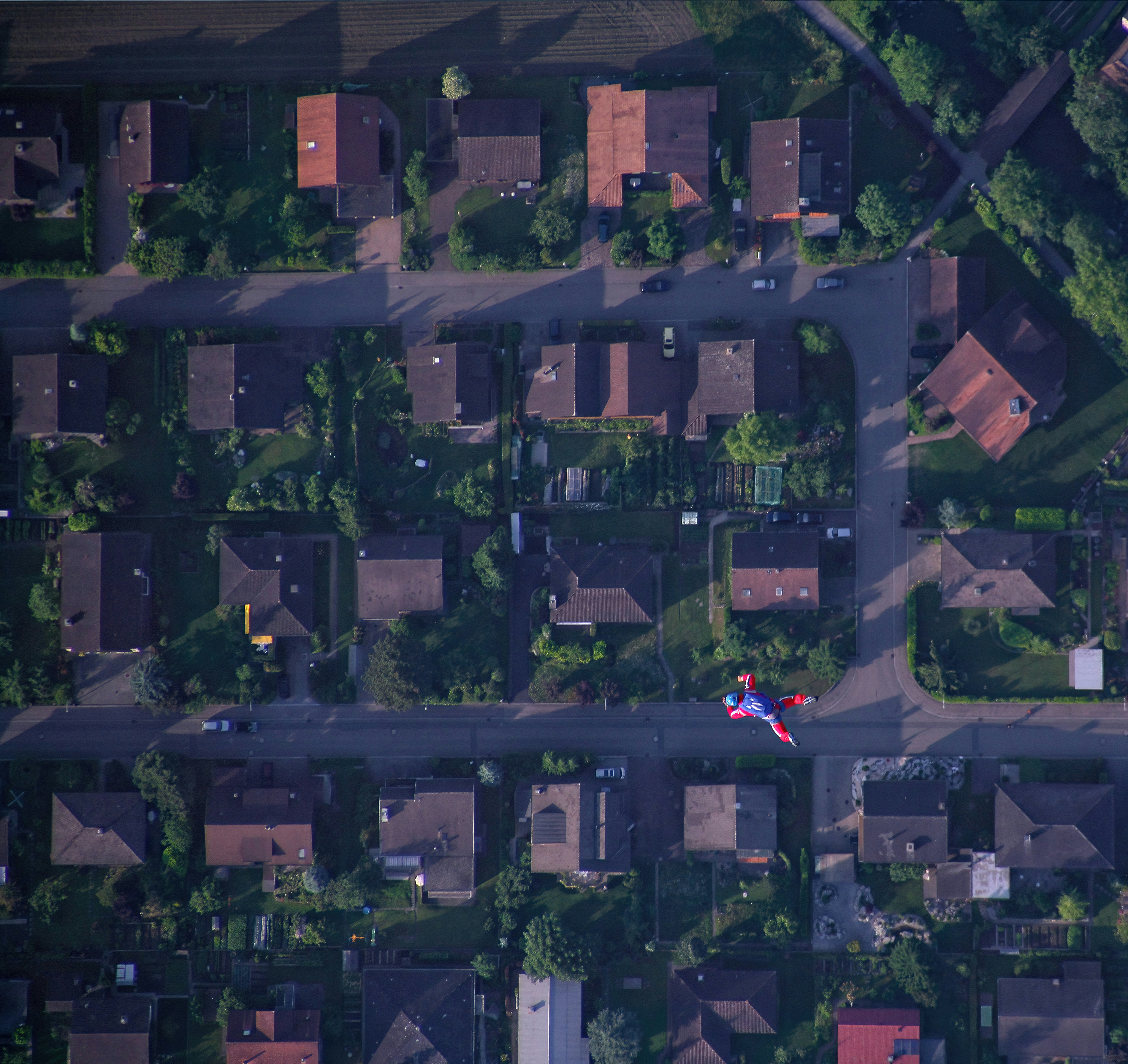 Aerial Quiet: A Suburban Neighborhood from Above with a Tiny Helicopter Gliding Along the Street