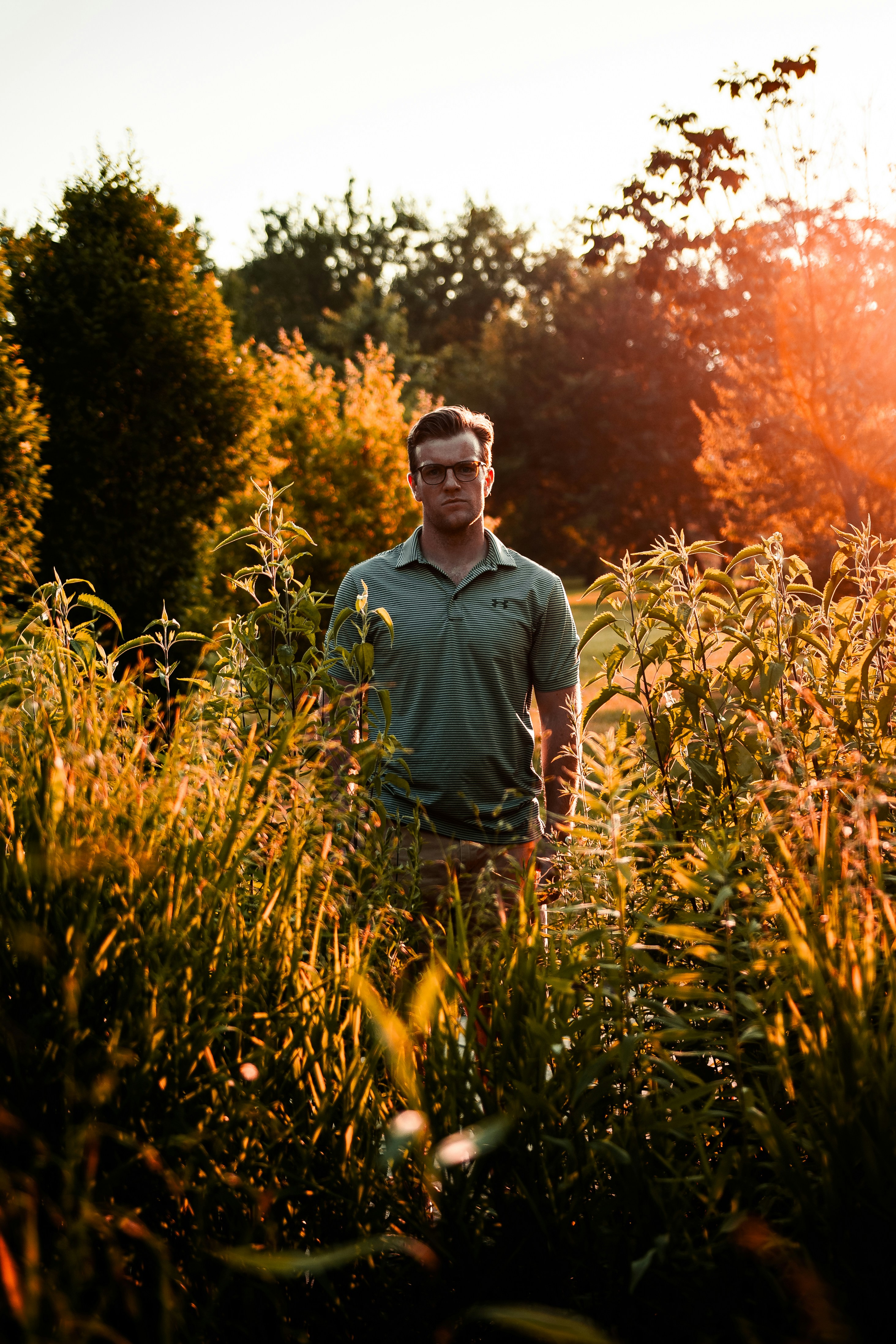 Man in gray crew neck t-shirt standing on green grass field during ...
