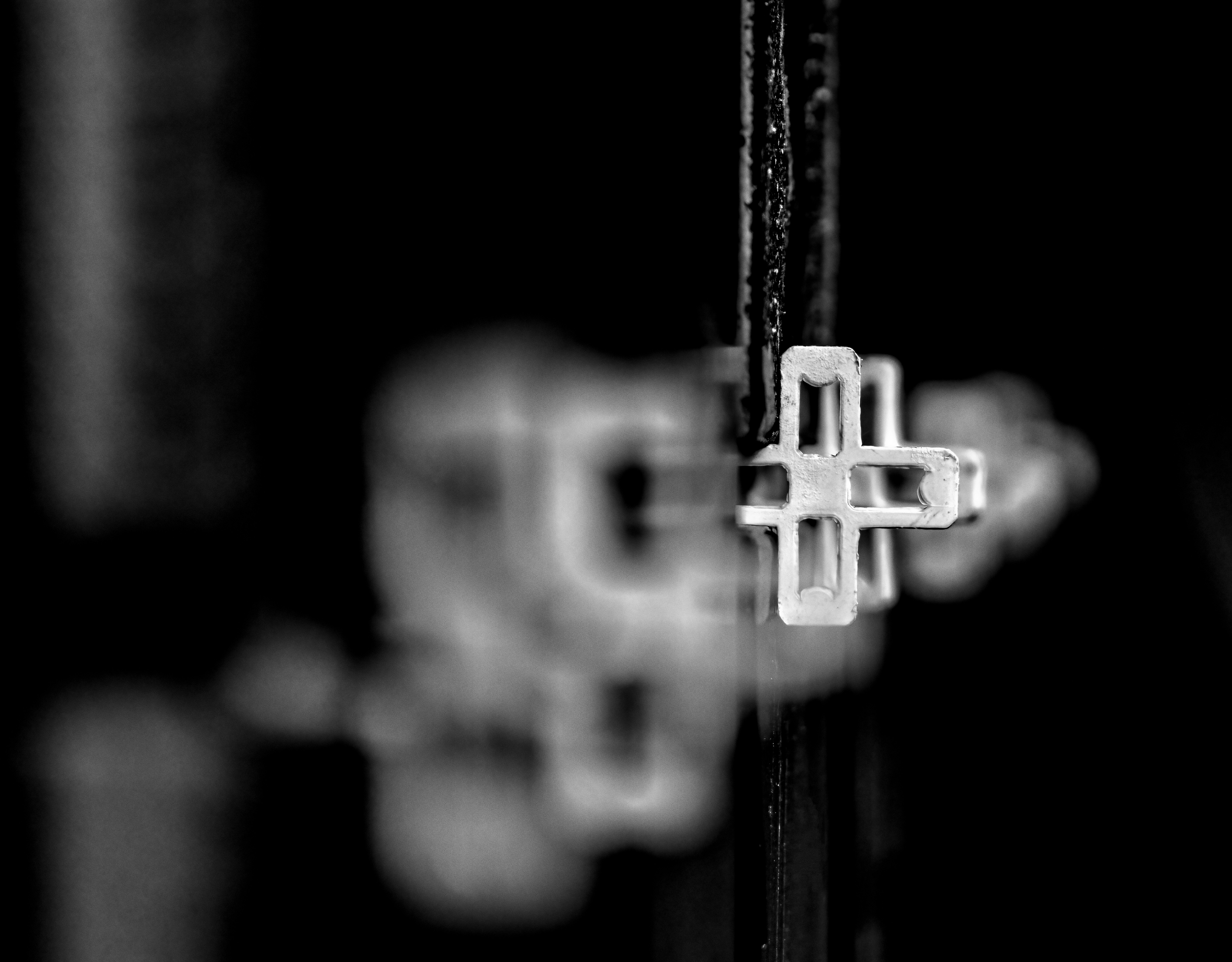 Abstract close-up of a white cross-shaped object against a dark background, emphasizing shapes and contrasts.