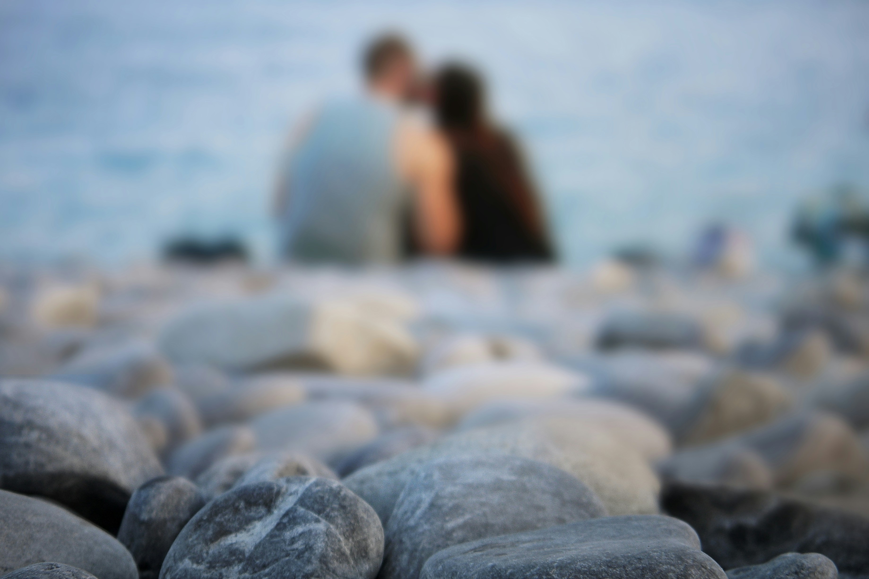 Pebble Beach Embrace: Quiet Moment by the Sea