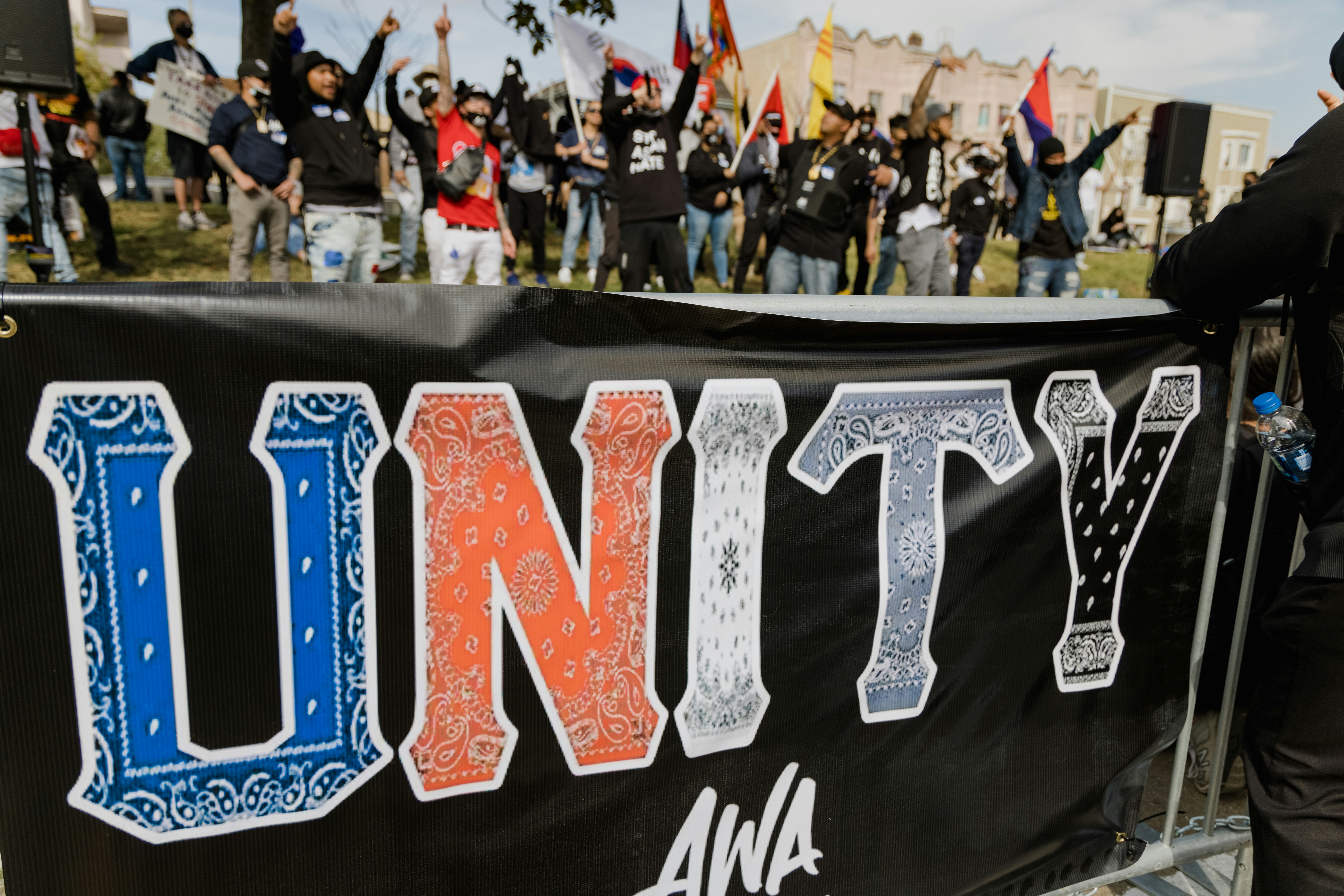 People gathered behind a large banner with 'UNITY' printed in bold letters.