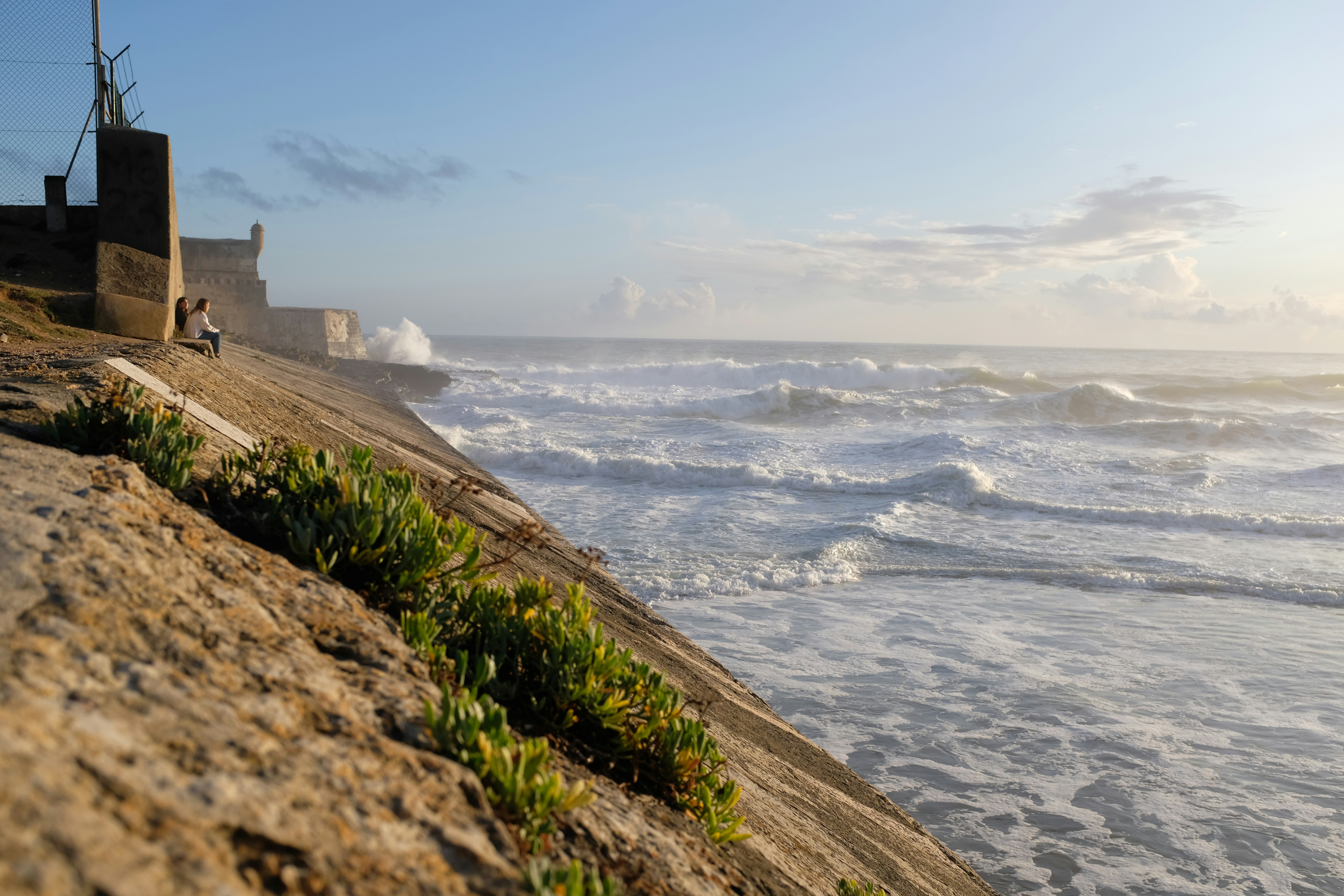 Evening on the Sloped Sea Wall: Quiet Figures Overlooking the Rolling Sea