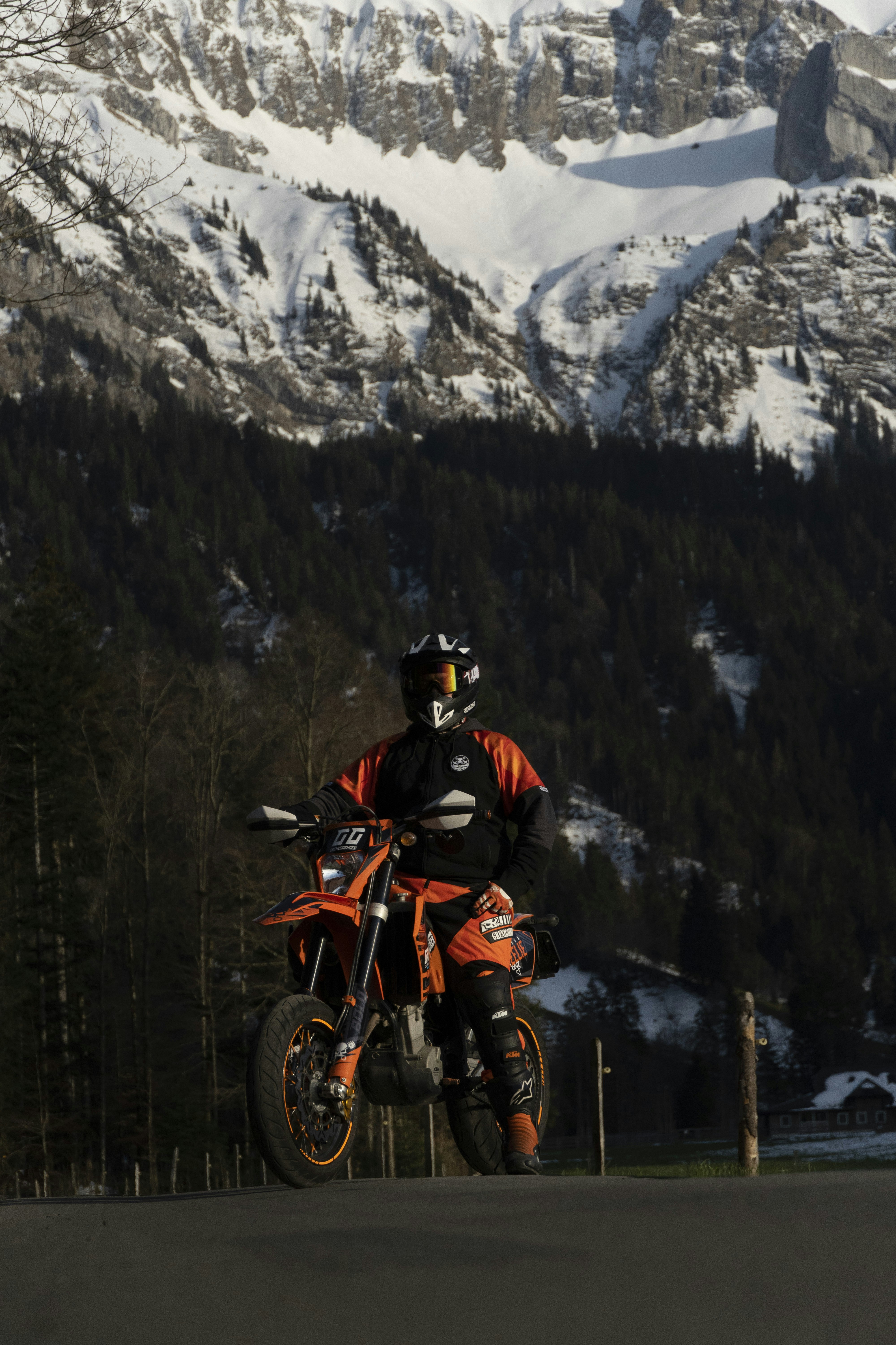 Orange KTM Rider Navigates a Snow-Dusted Alpine Road