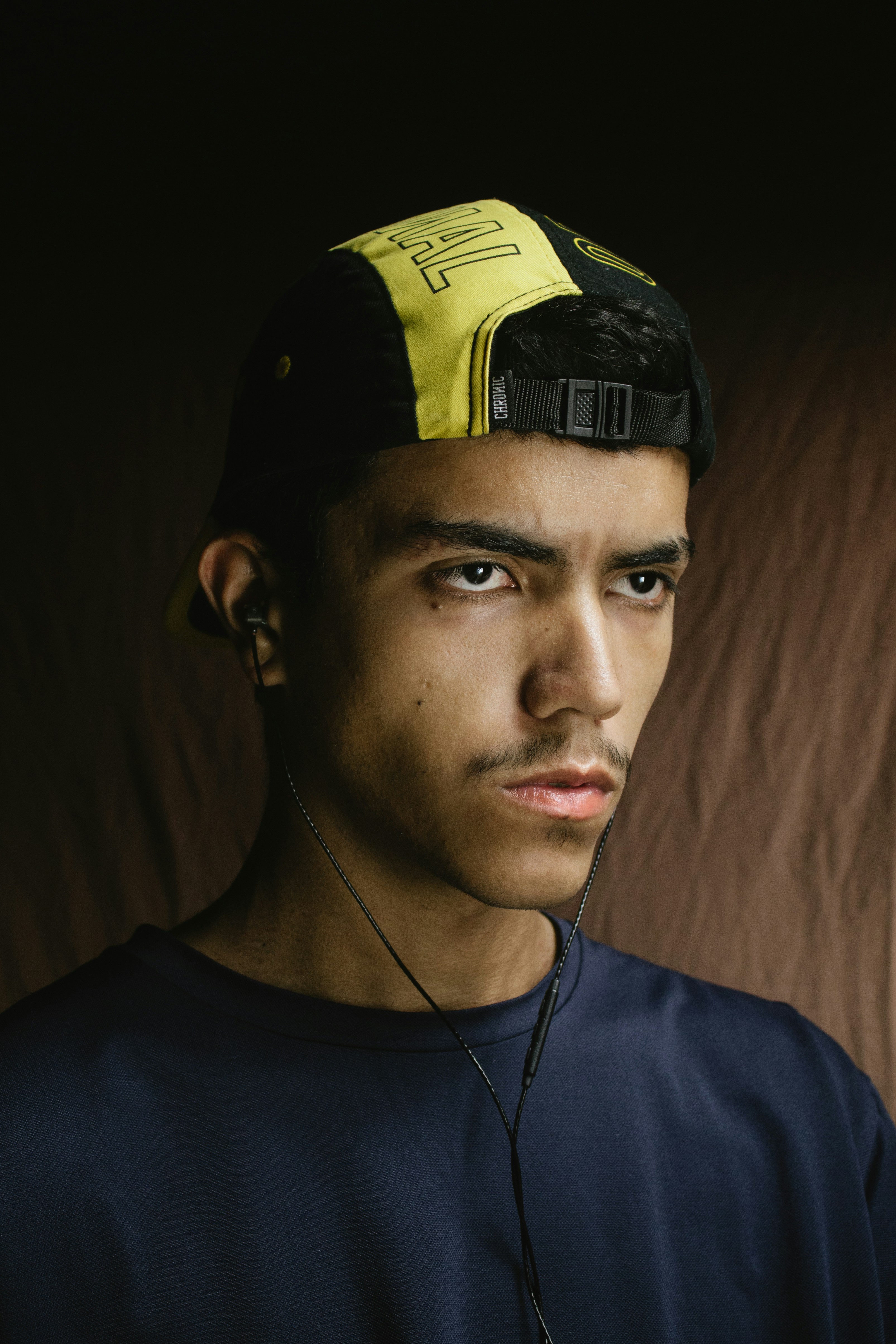 Man in blue crew neck shirt wearing black and yellow fitted cap photo ...