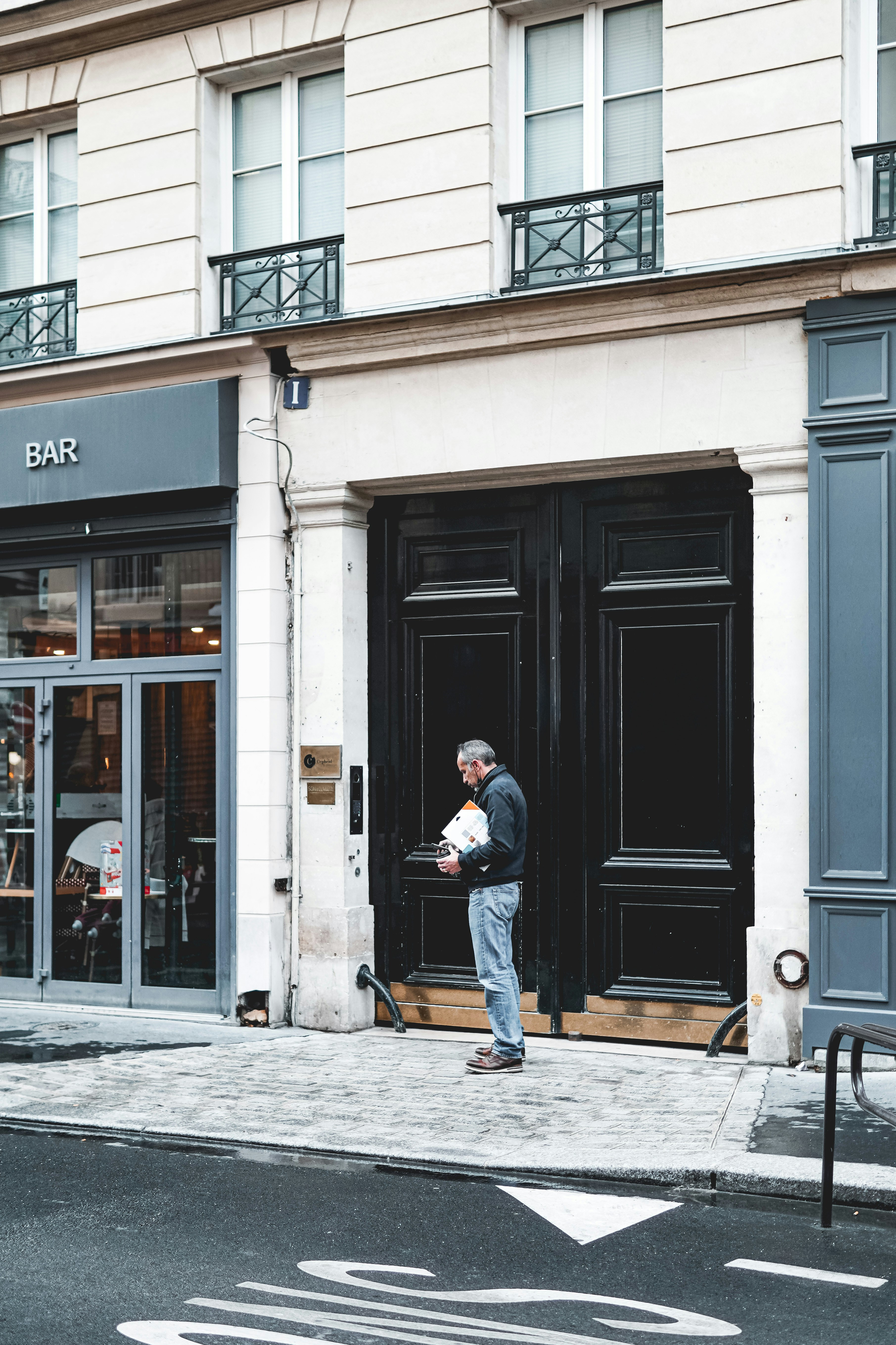 Doorway Messenger: A solitary figure by the Parisian Barfront