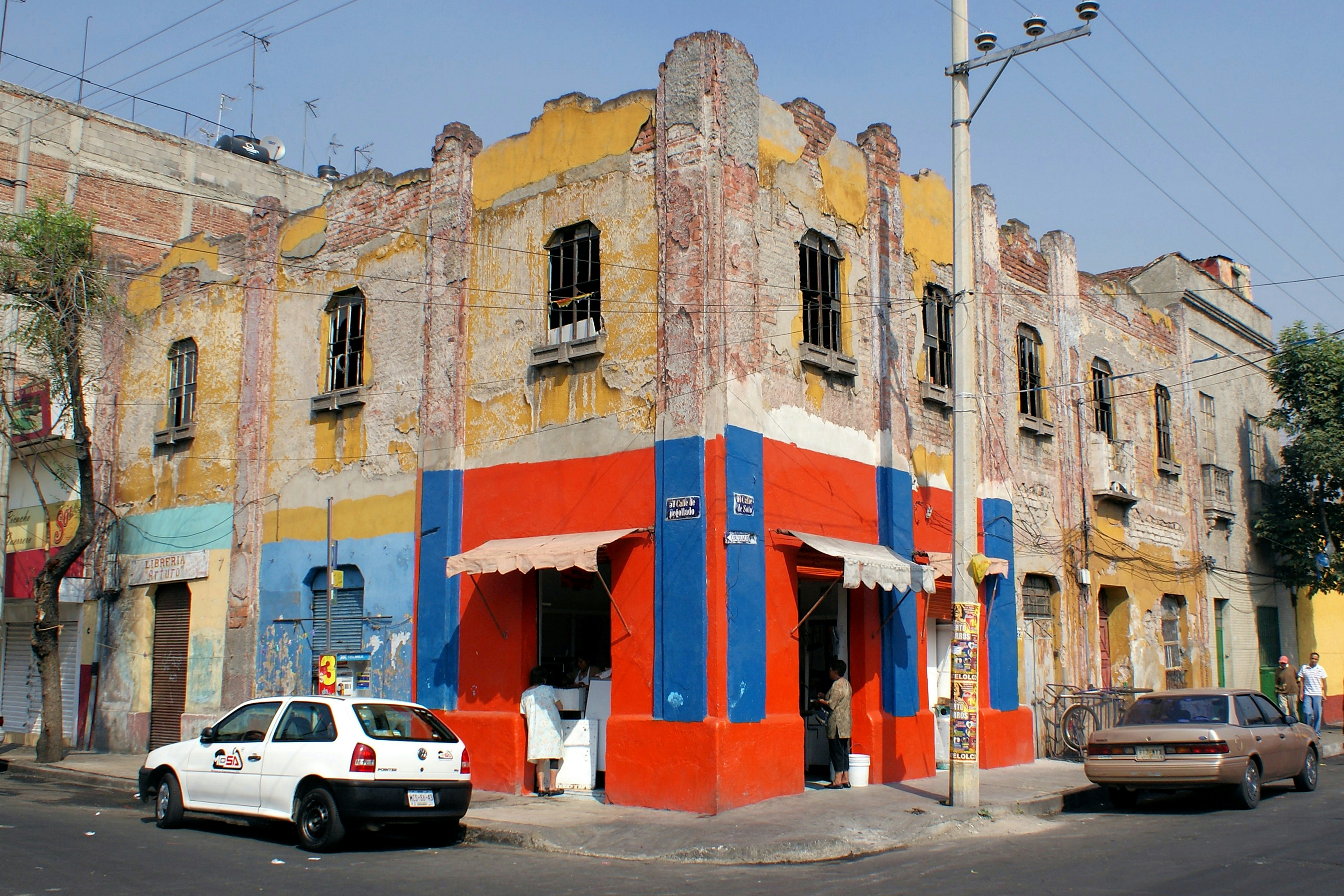 Colorful, weathered building at a street corner in San Rafael with vibrant yellow, blue, and red walls.