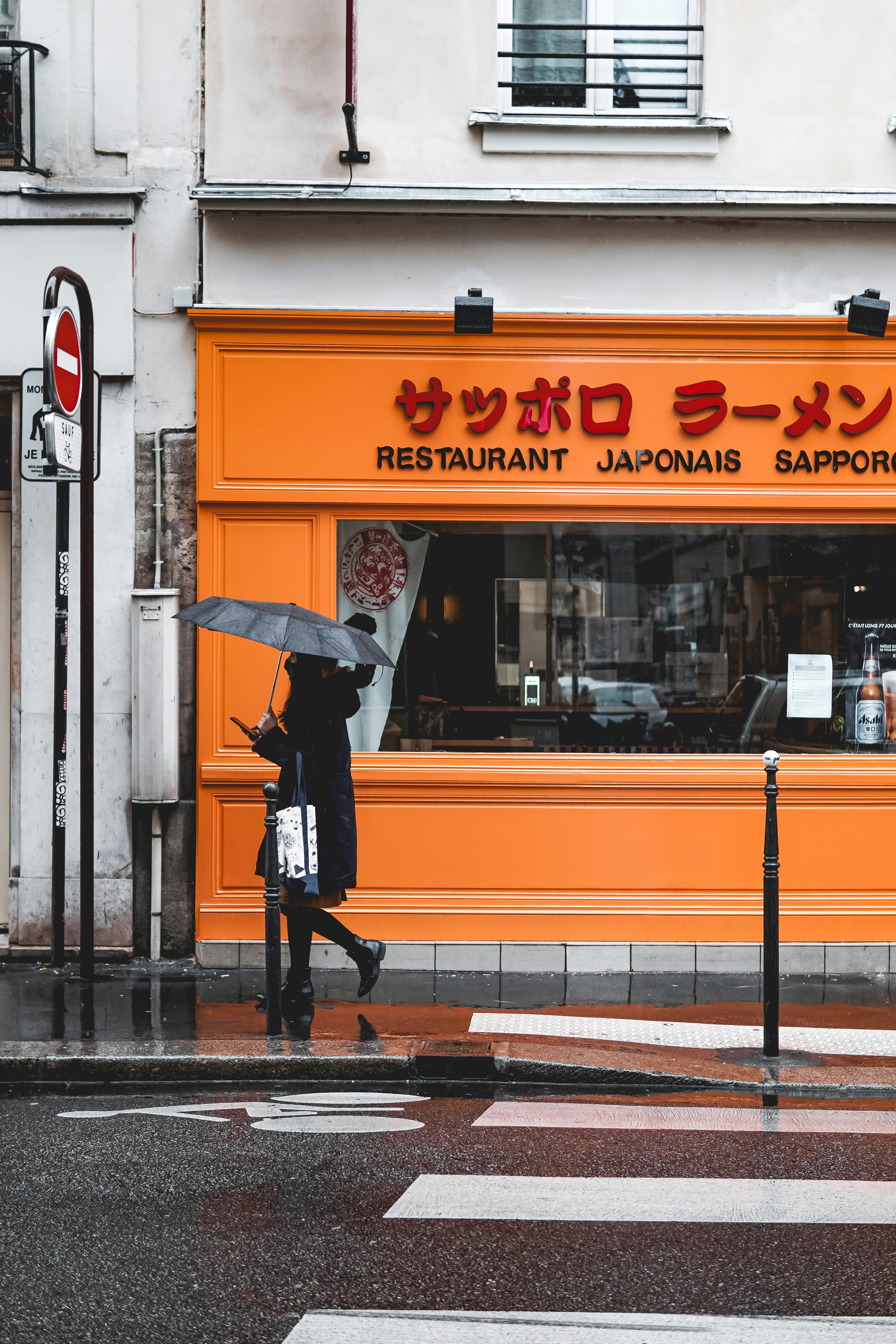 Orange Appetite: A Street Window Frame with Snow-Glazed Pedestrian