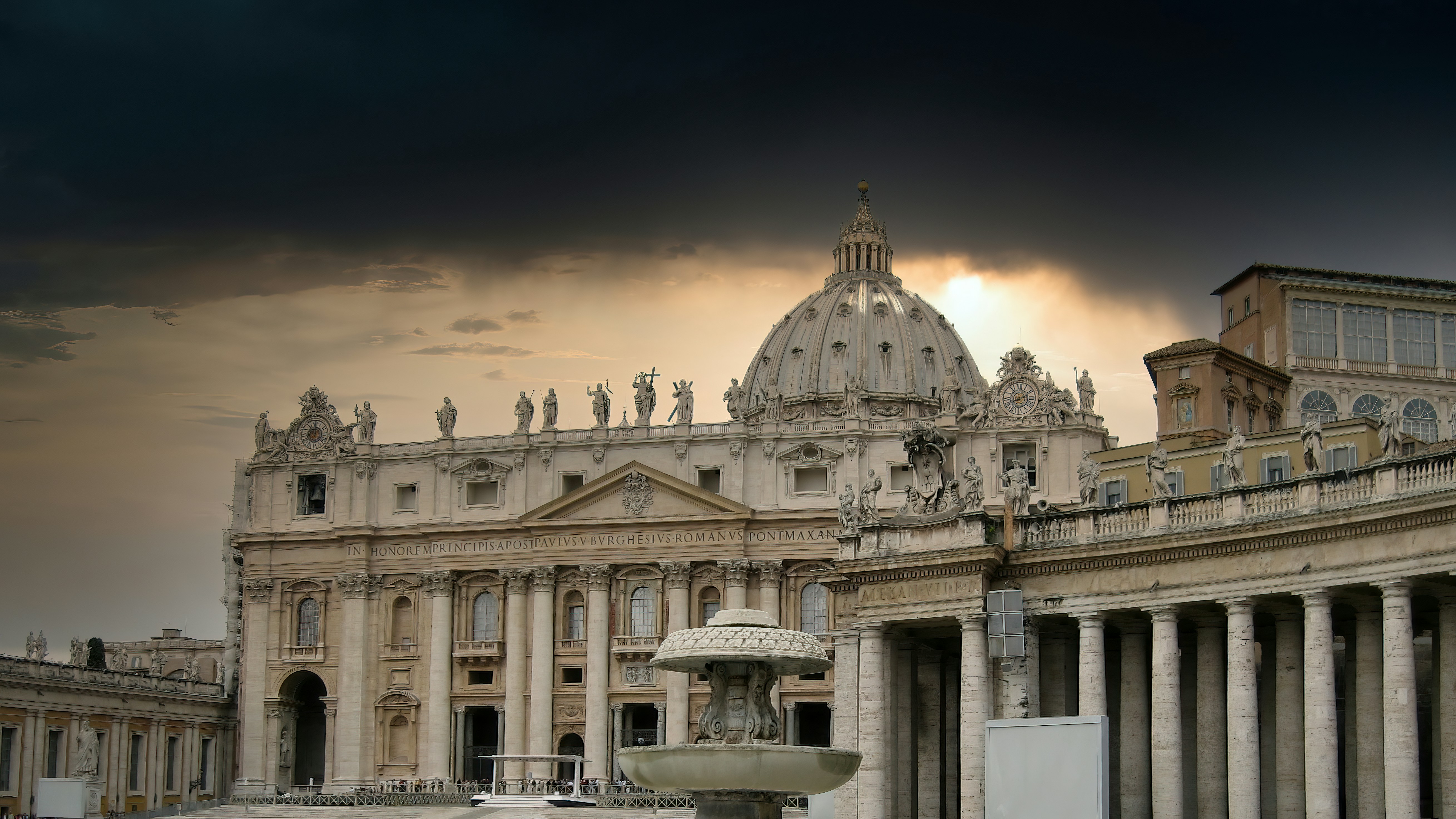 St. Peter's Basilica under dramatic storm clouds with sun breaking through.