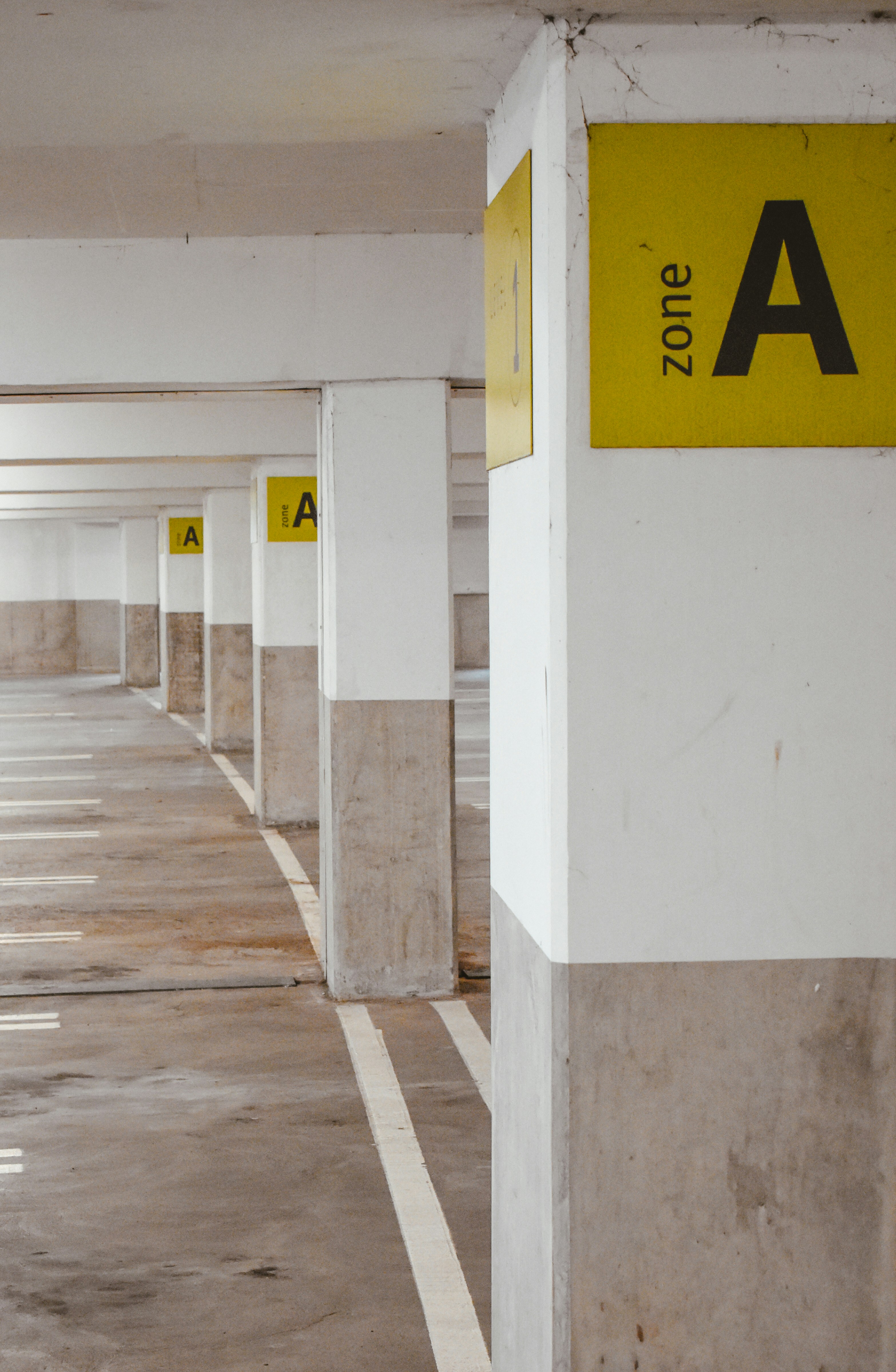 Empty parking garage with clearly marked zones, highlighting the architectural design and organization of space.