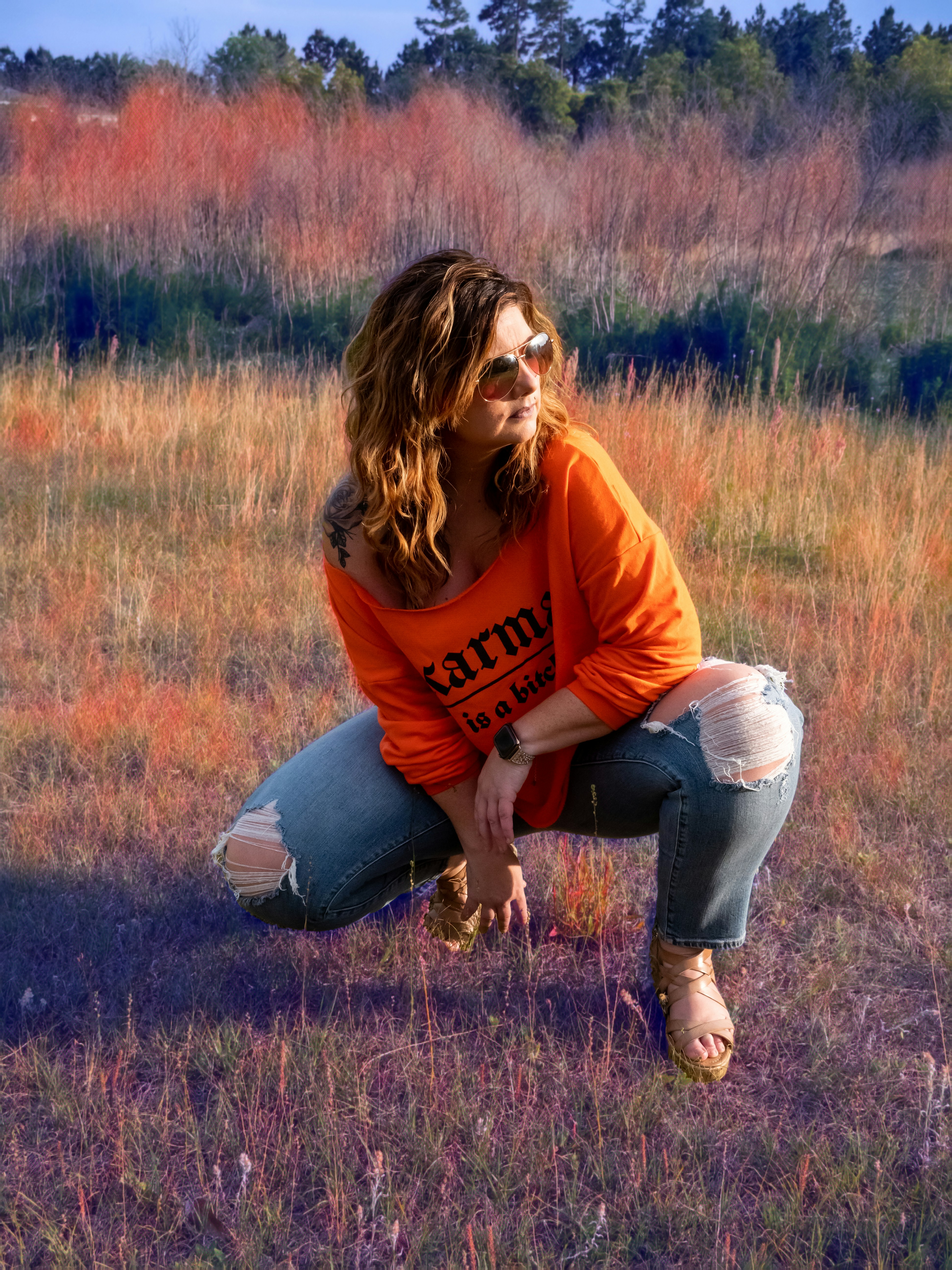Orange Quietude: A Crouched Portrait Among Lavender-tinged Grasses