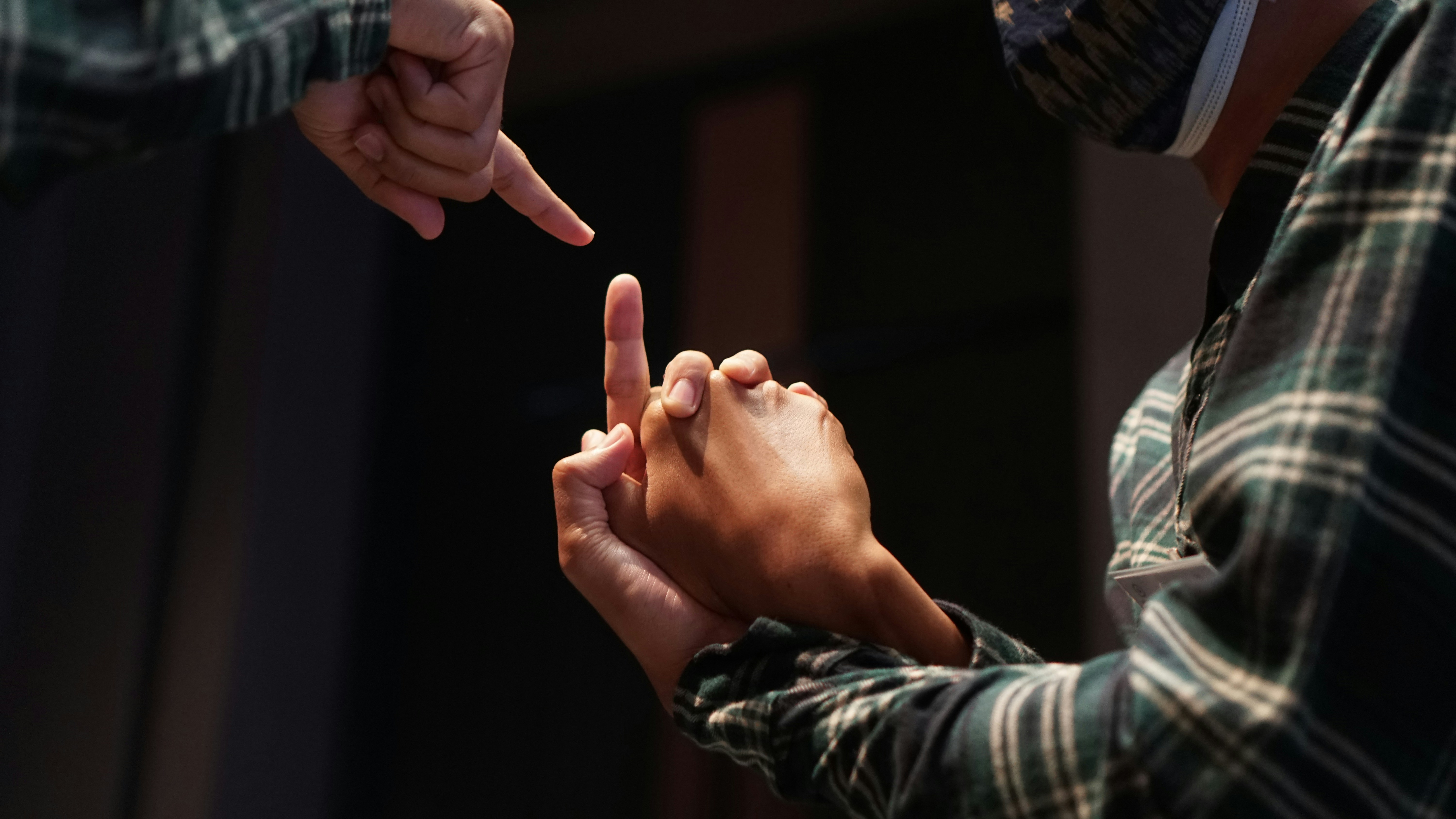 Man in black and white plaid dress shirt showing his middle finger ...