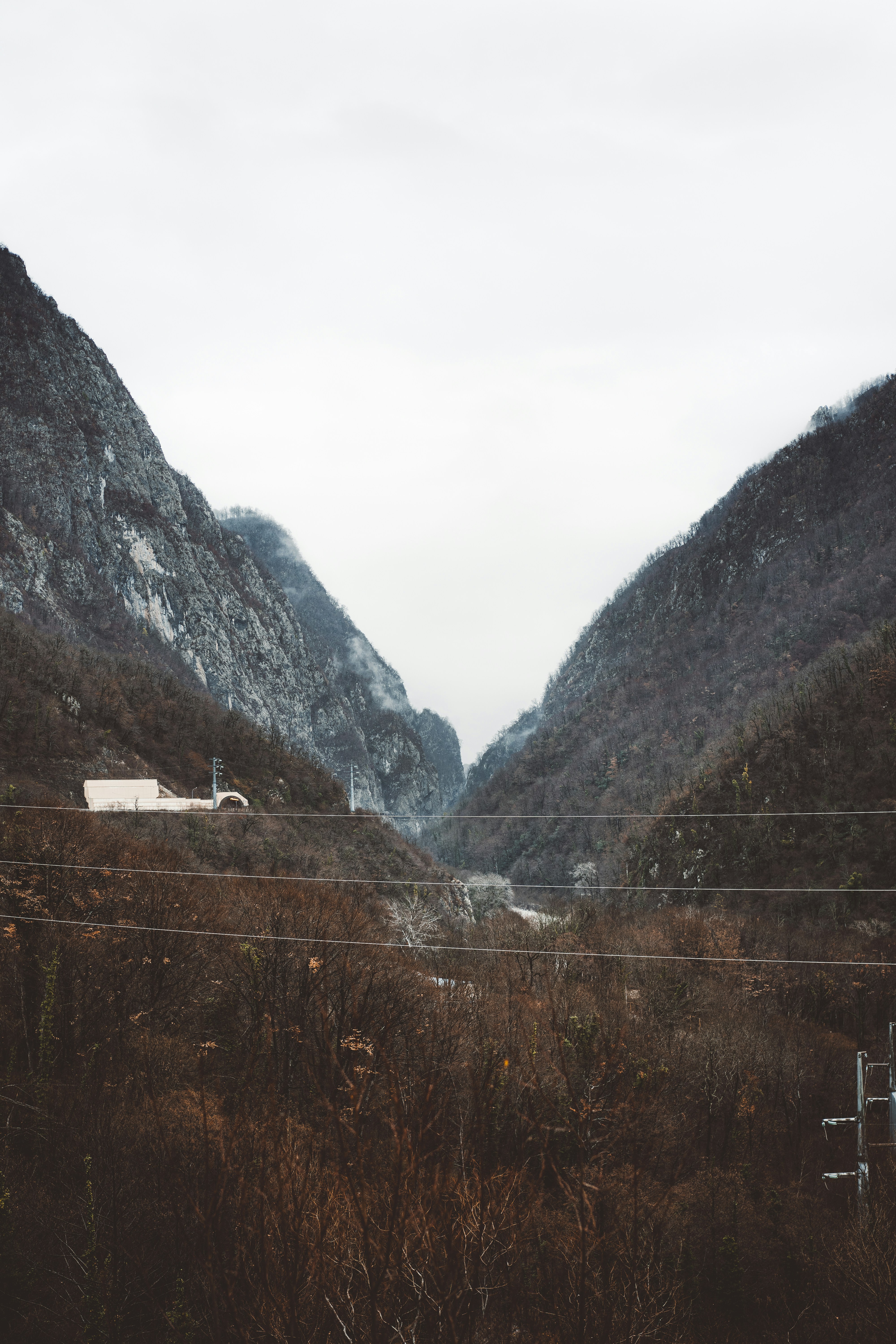 White Truck Tracing a Mountain-Valley Corridor Under Steely Skies