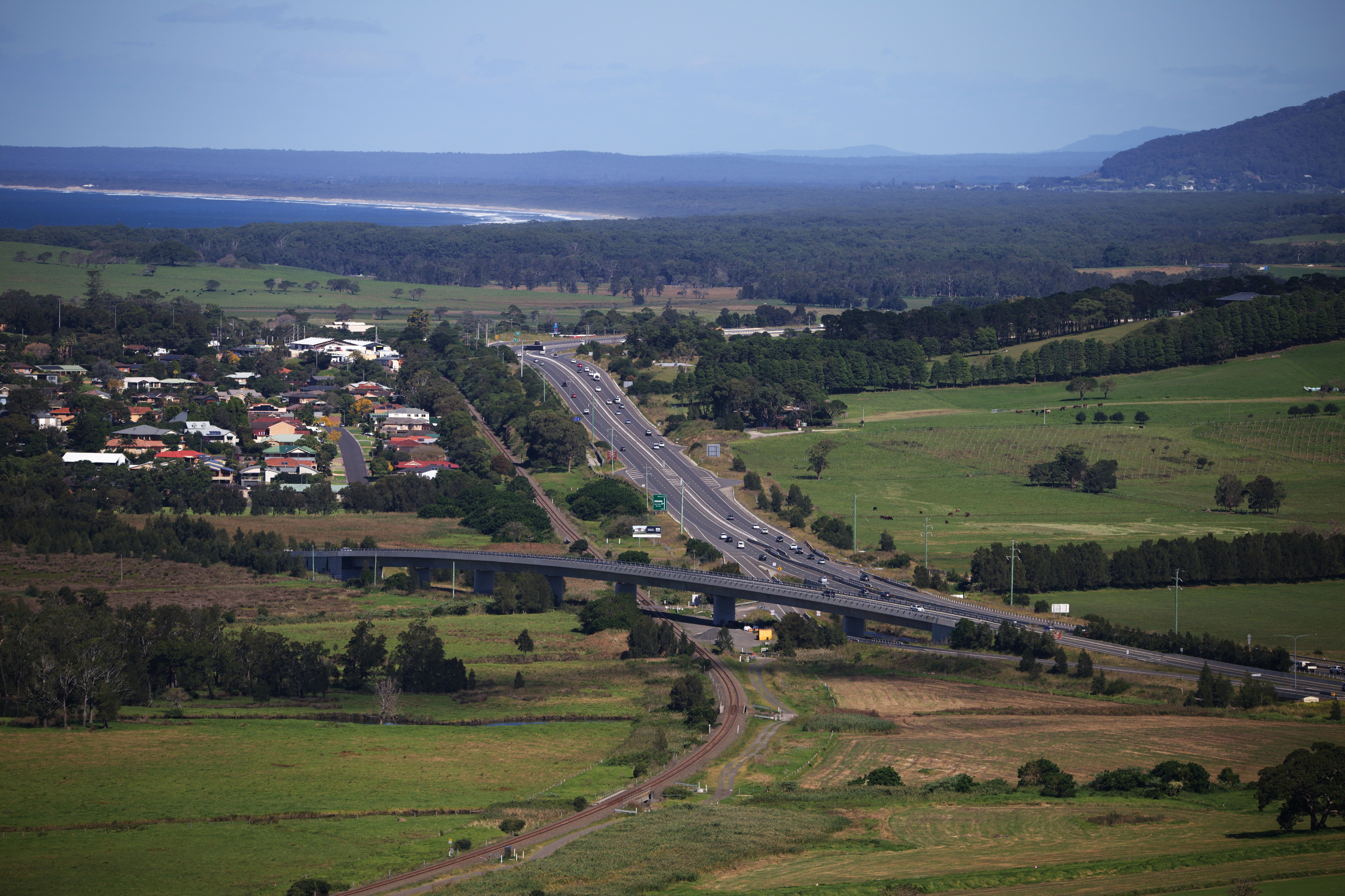 Aerial view showcasing the intersection of a highway and rural landscape, highlighting the contrast between urban development and natural greenery.