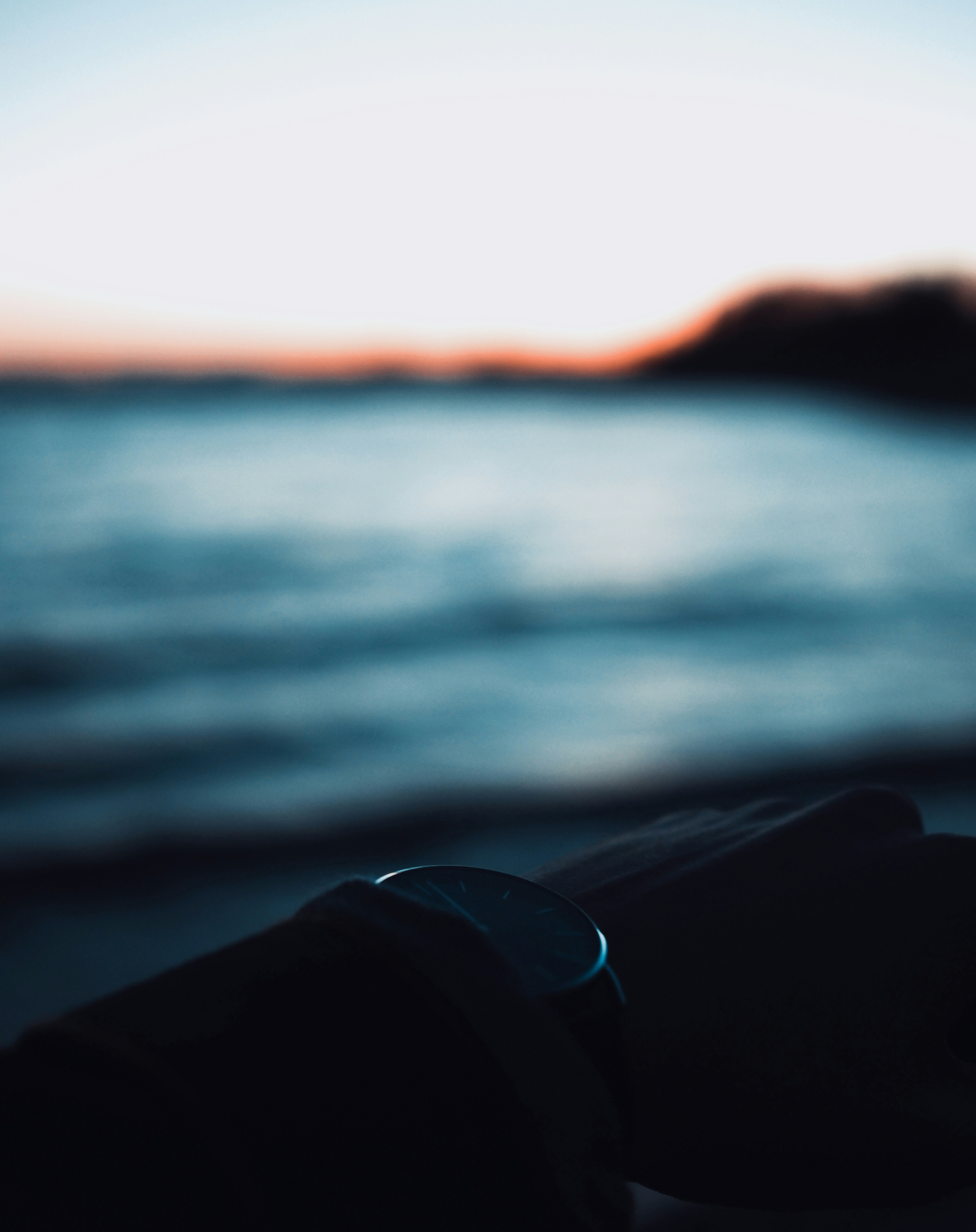 Dusk on a Quiet Sea: A Blurred Horizon Framed by a Wristwatch