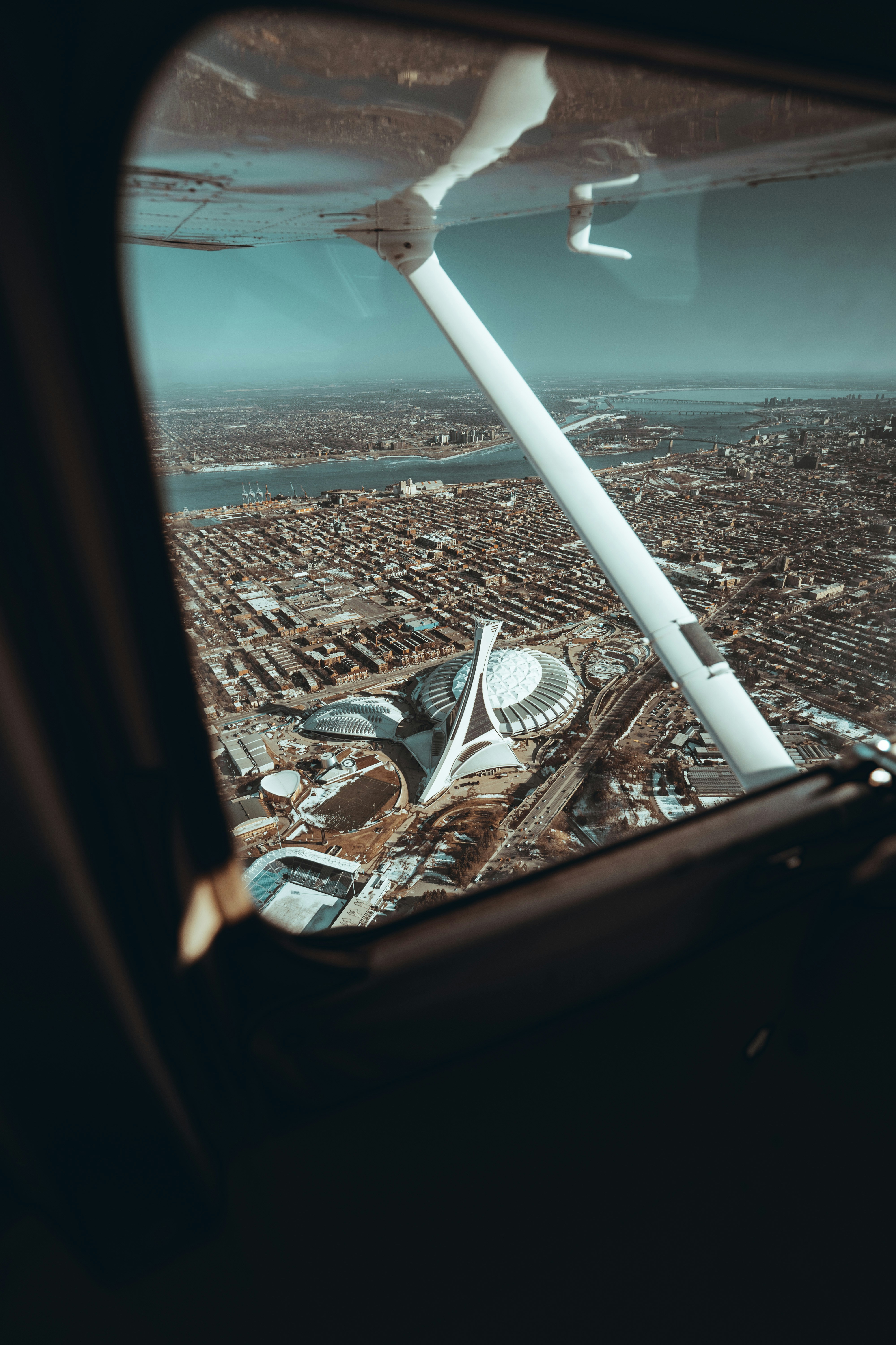 Wing-Frame Over the Riverfront: An Aerial Peek at a Futuristic City