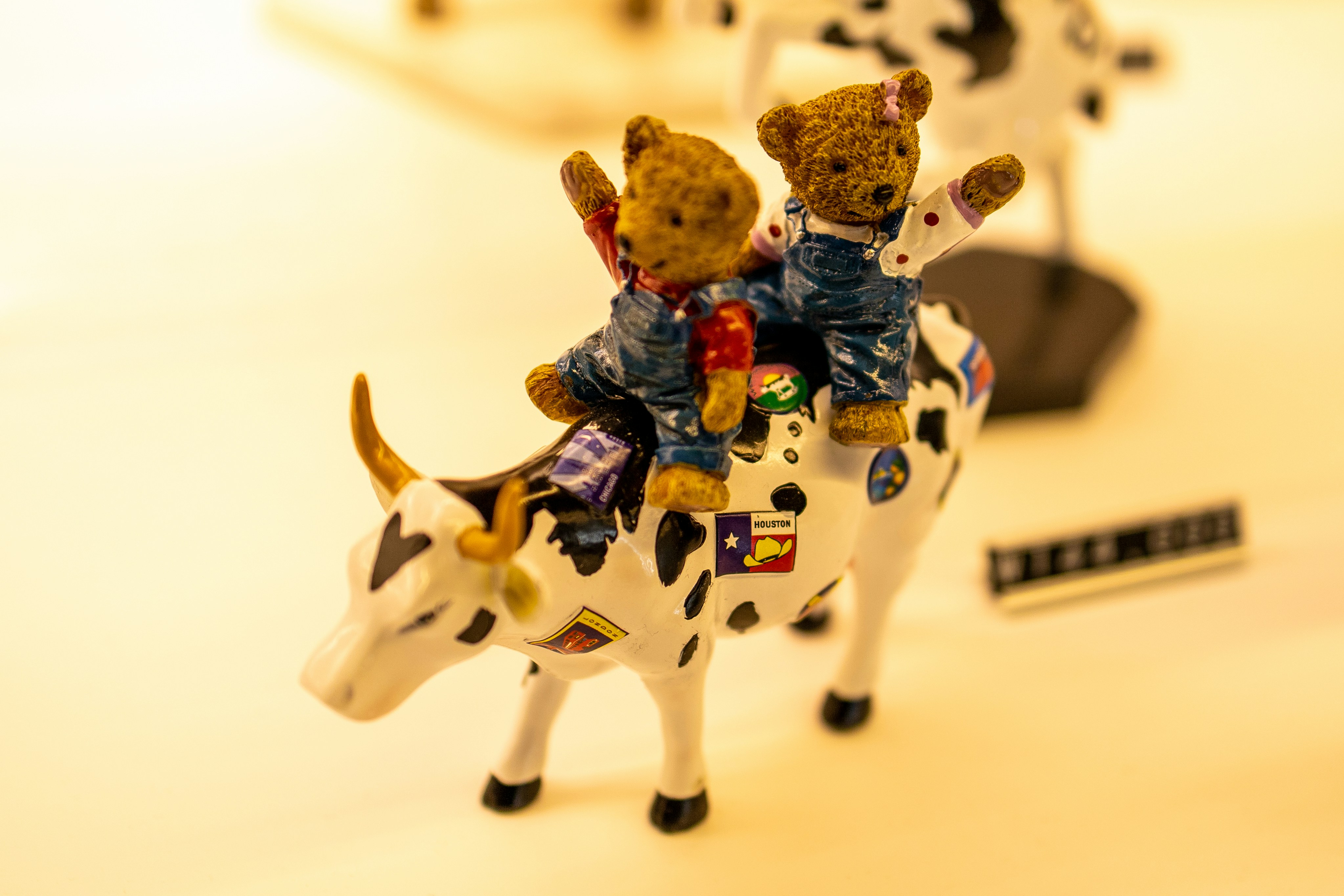 Sticker-Decorated Cow: Teddy Riders in a Warm Amber Glow